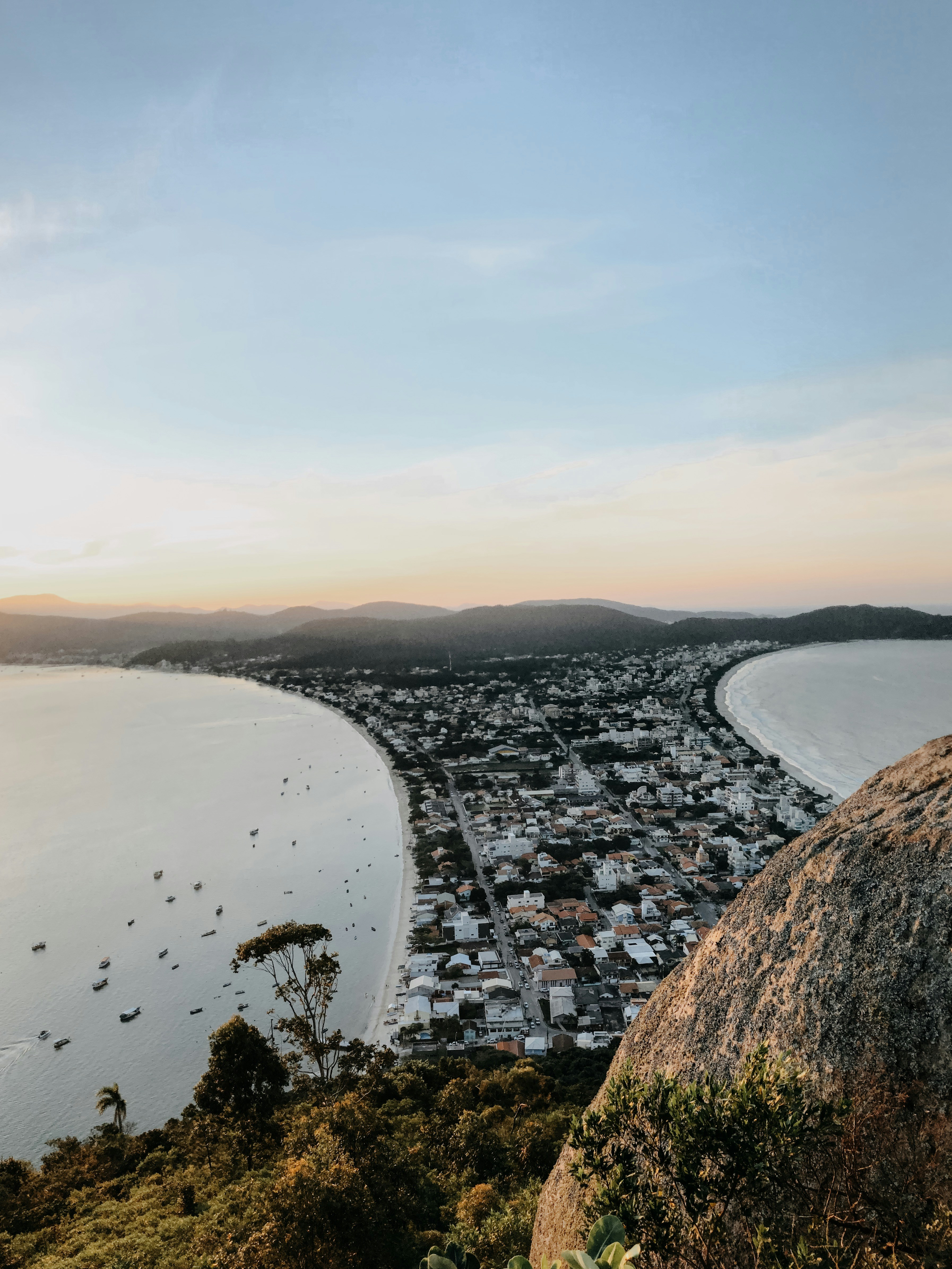 Cliffside panorama: a coastal town nestled between sea and hills at sunset