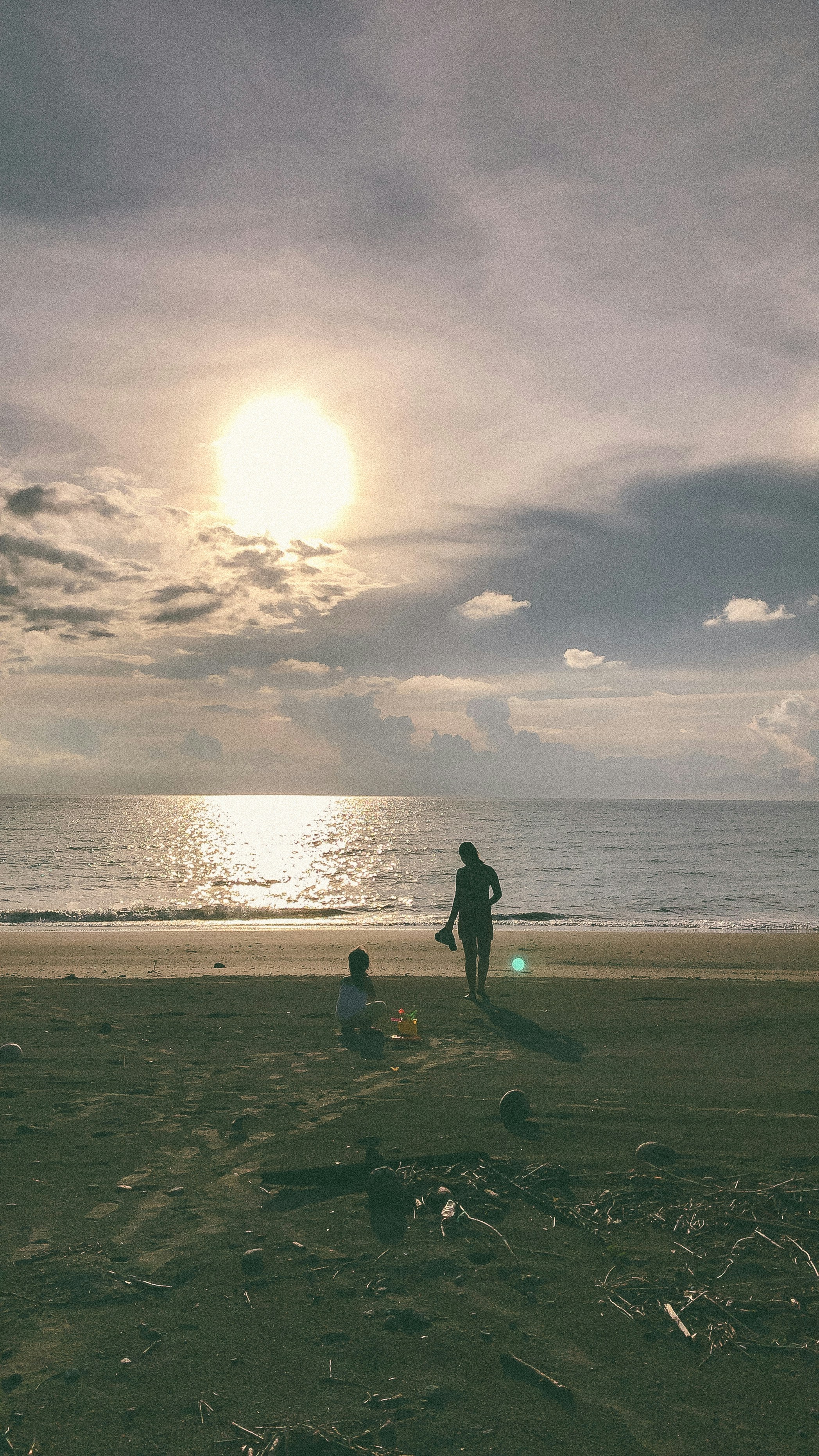 Sunset Silhouettes at the Waterline: A Quiet Beach Moment