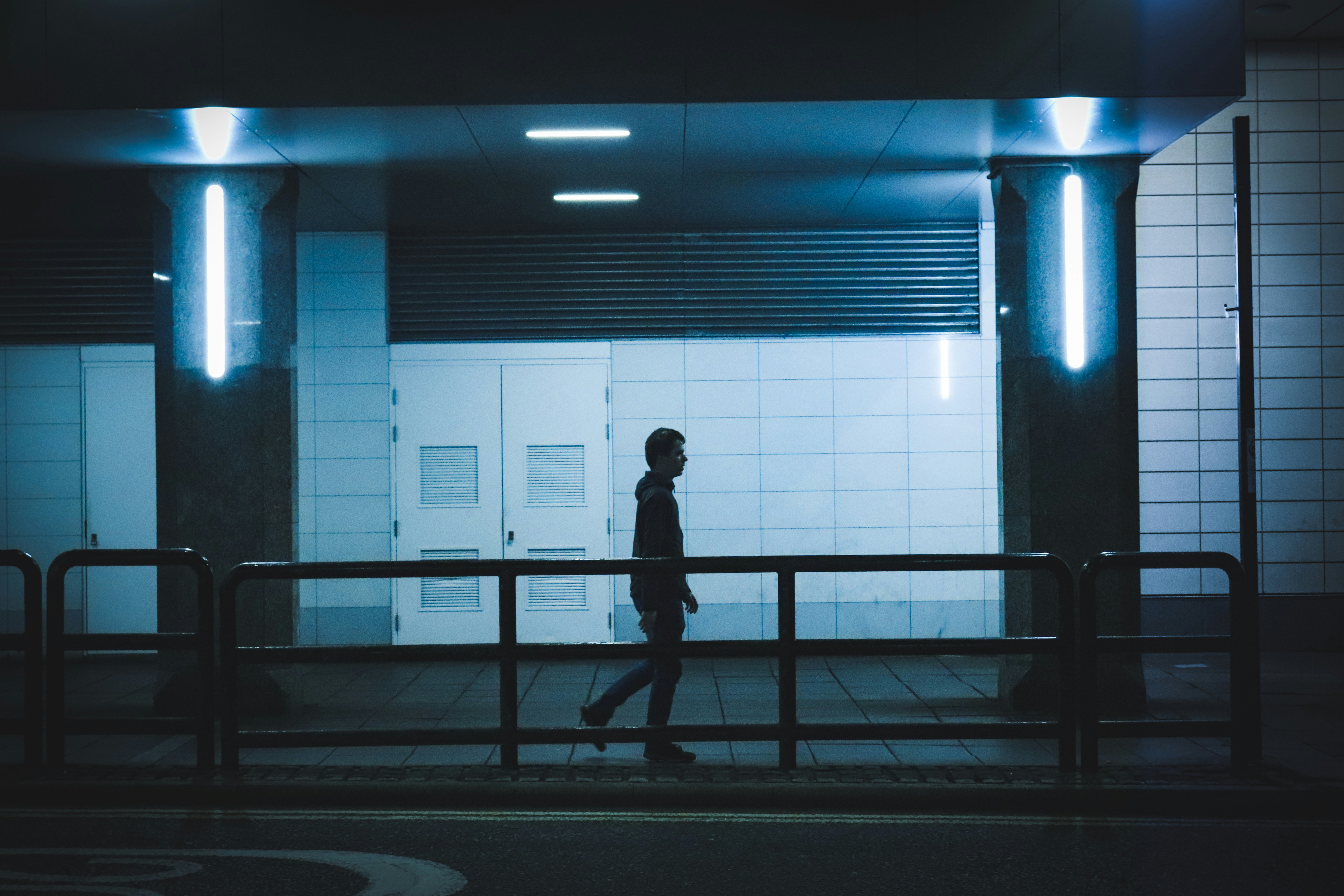 Man walking inside building photo – Free Blue Image on Unsplash