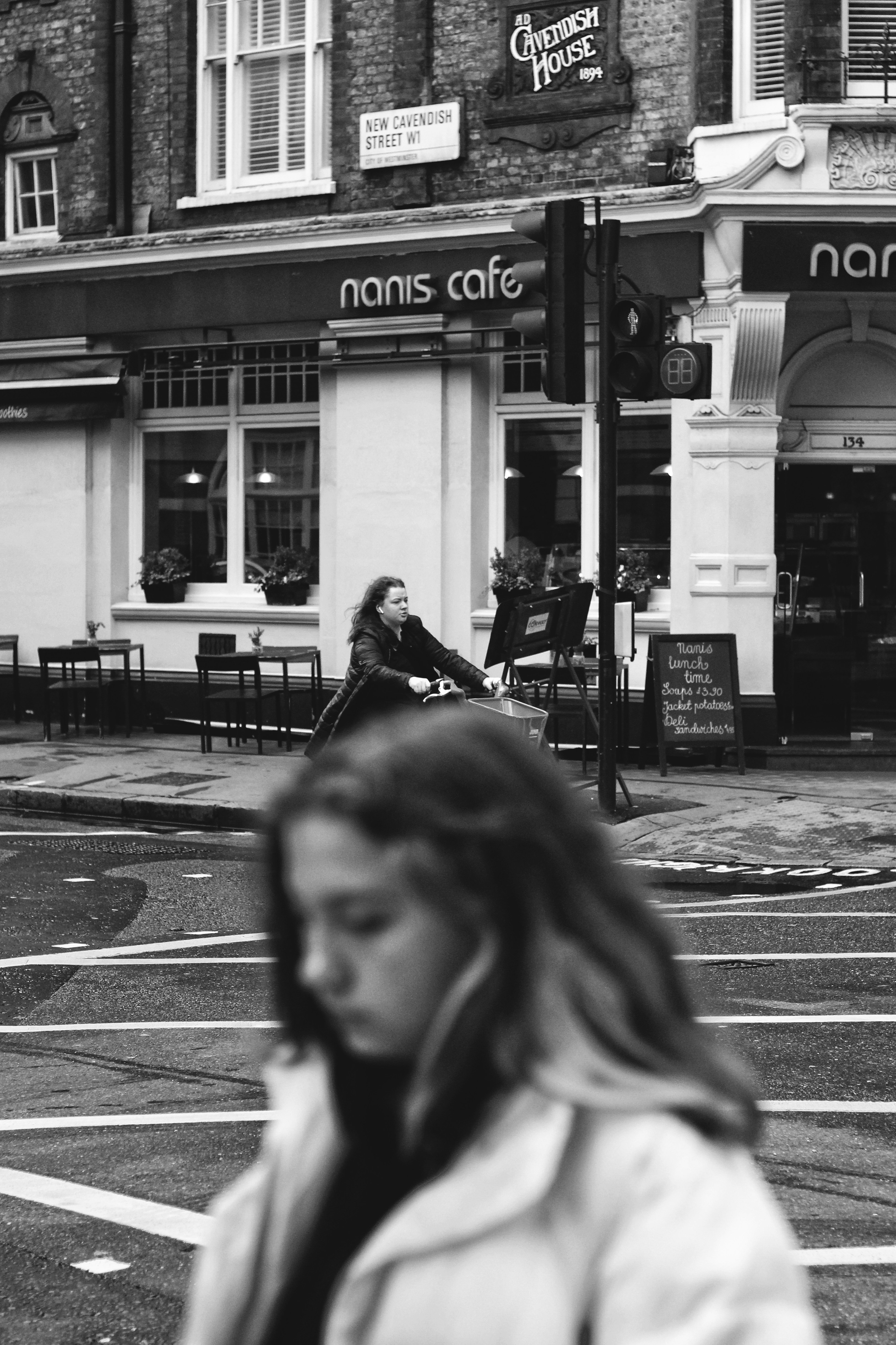 Cyclist Along Nanis Cafe Row: Motion Framed by a Blurred Foreground