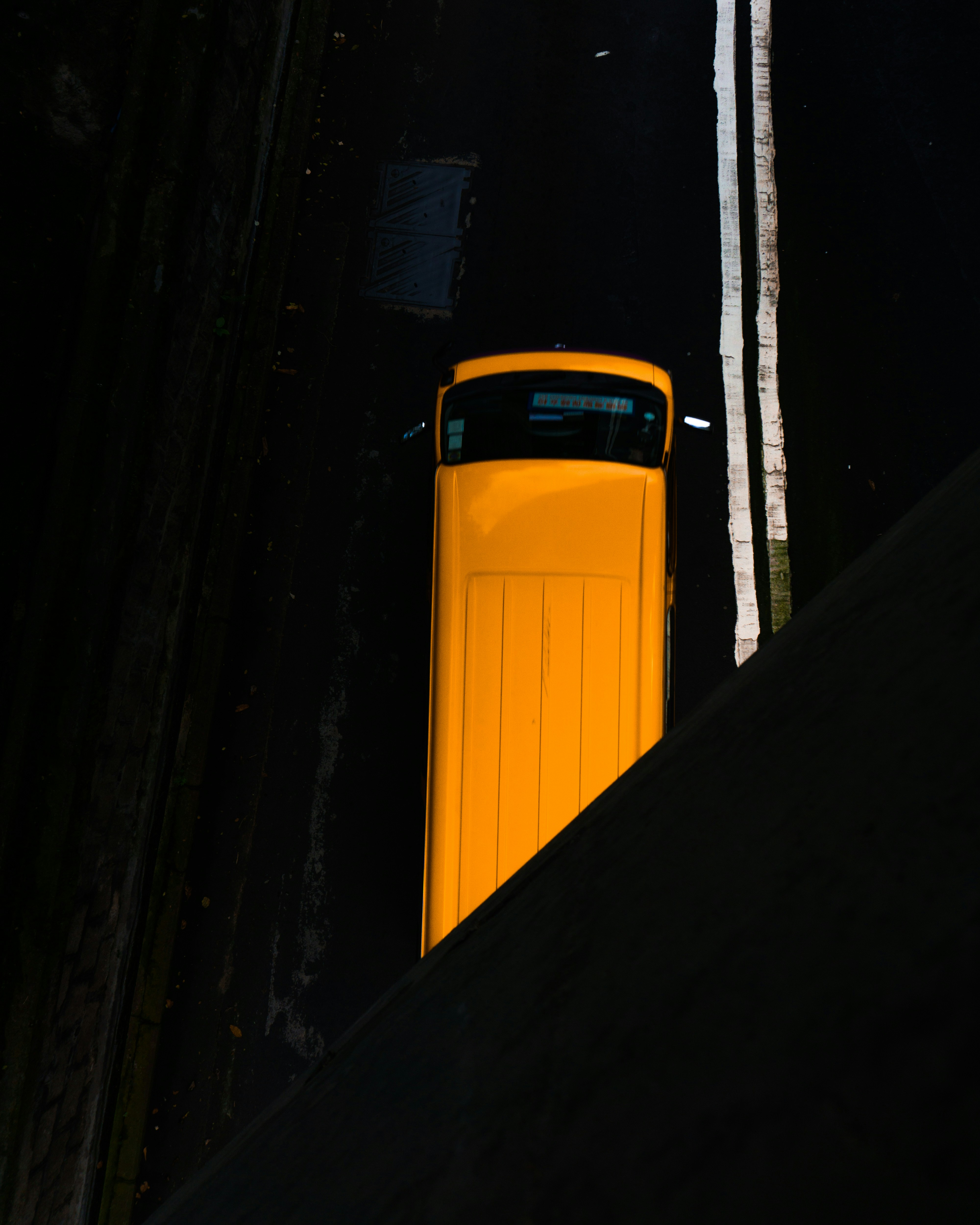 Vertical Transit: A Bright Yellow Bus Traverses a Dark Street