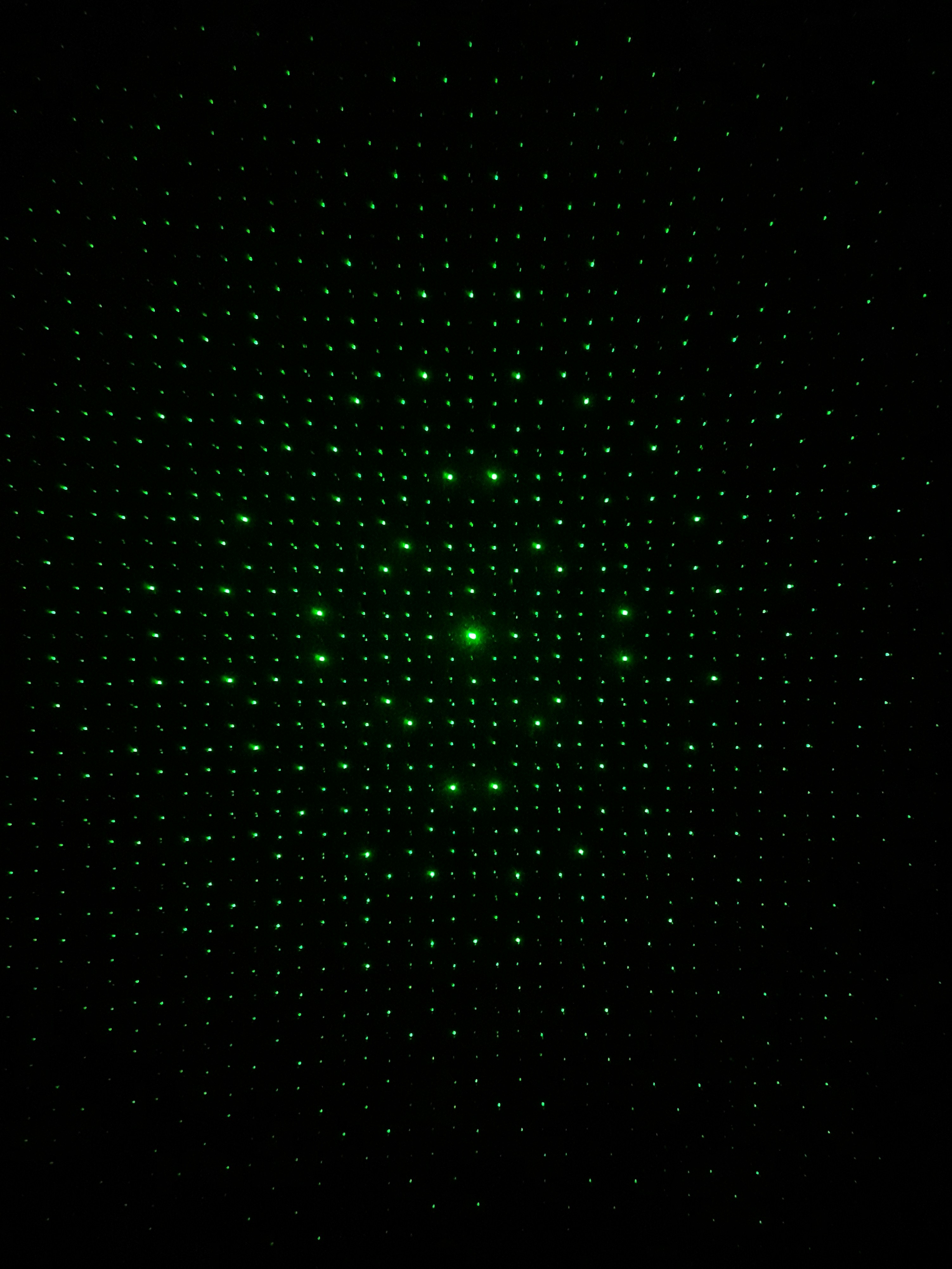 Pattern of glowing green dots forming a grid on a dark background.