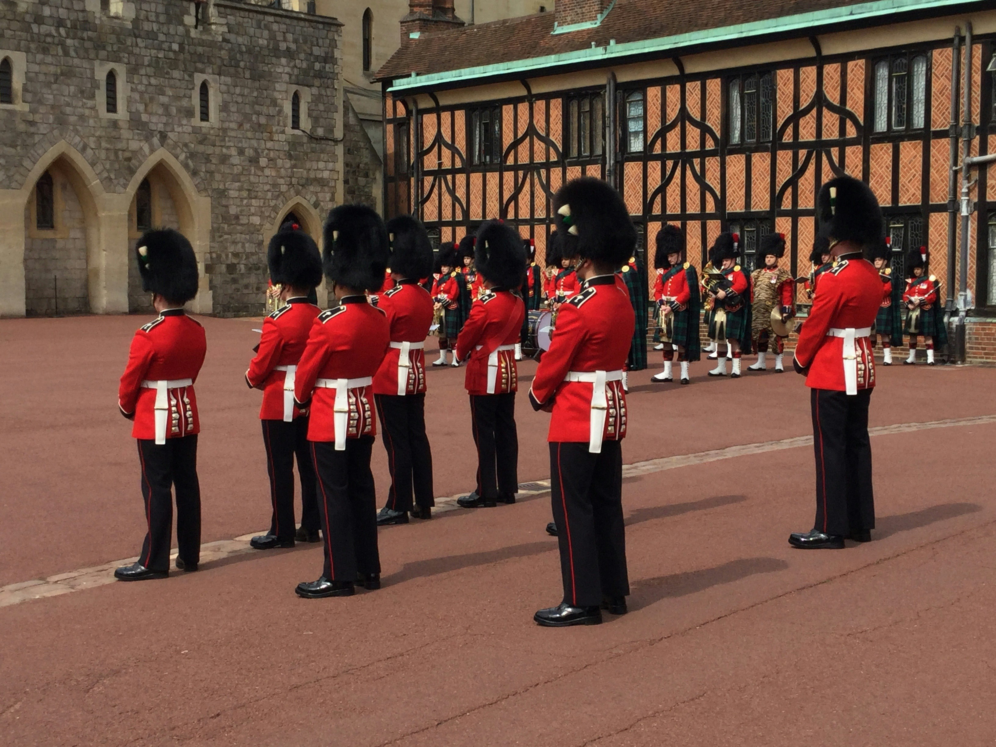 Changing of the guard, Windsor Castle | men in red suit standing on field