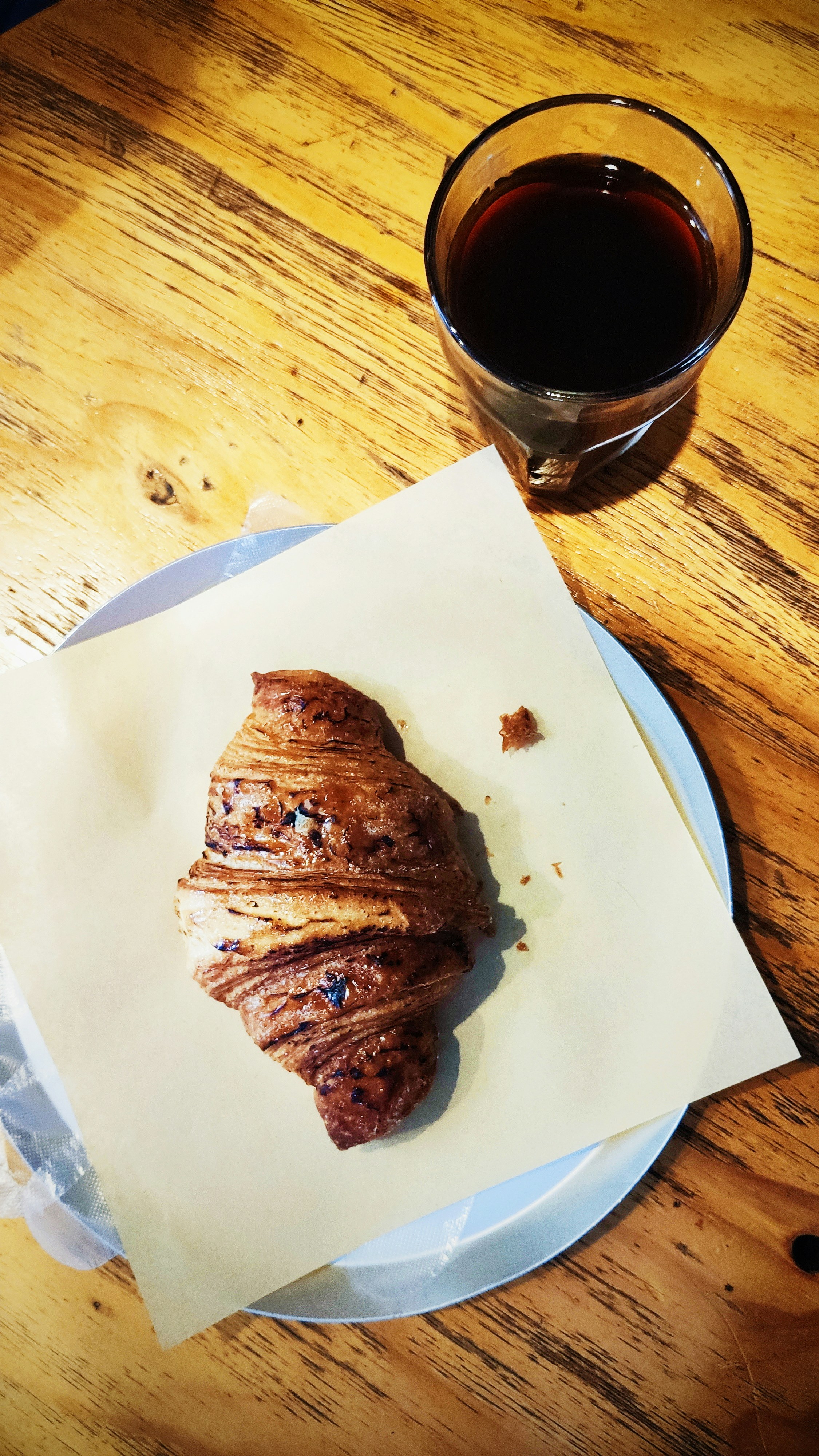 Croissant and Crimson: A Quiet Snack on Warm Wood