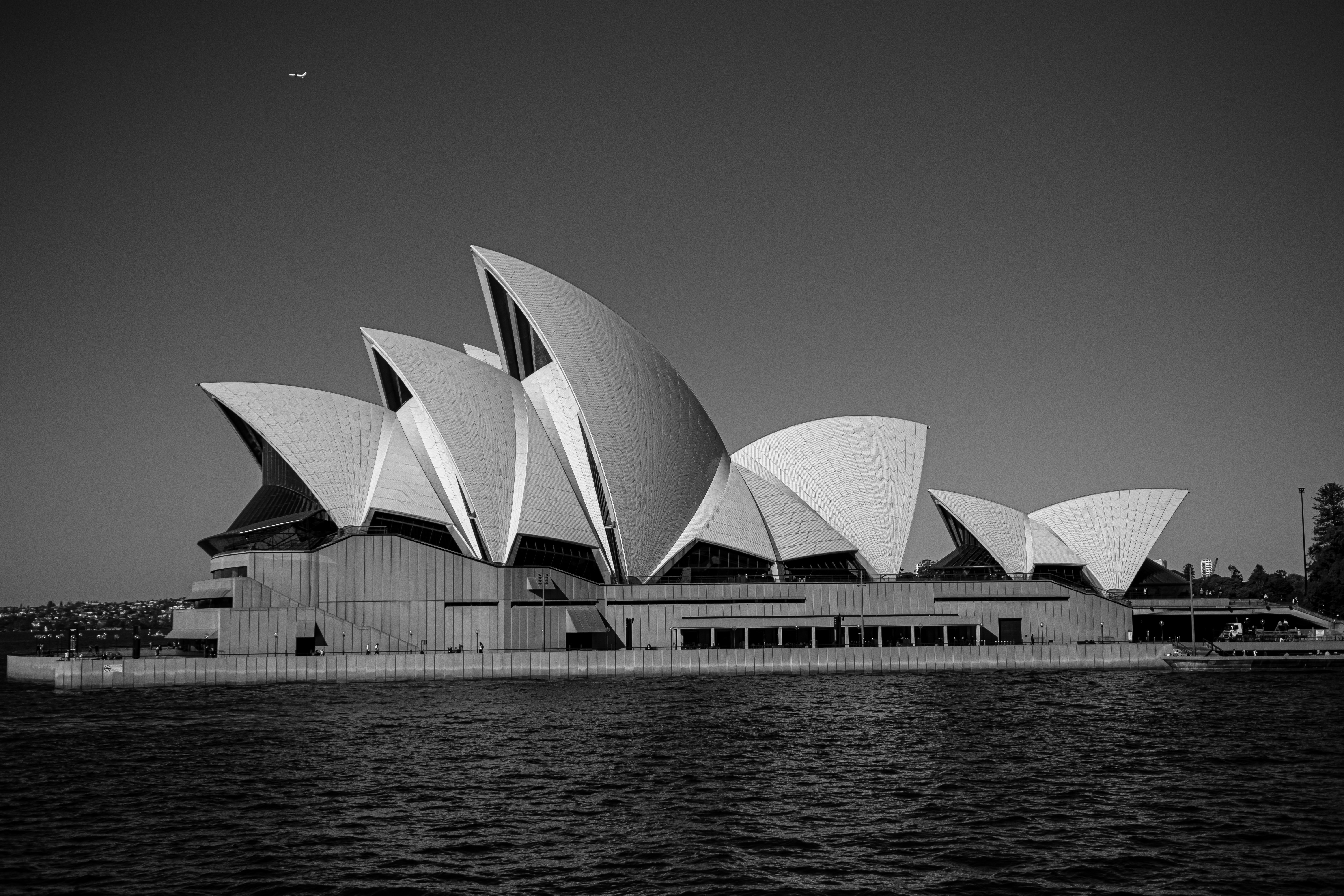 Grayscale view of the iconic Sydney Opera House against a clear sky.
