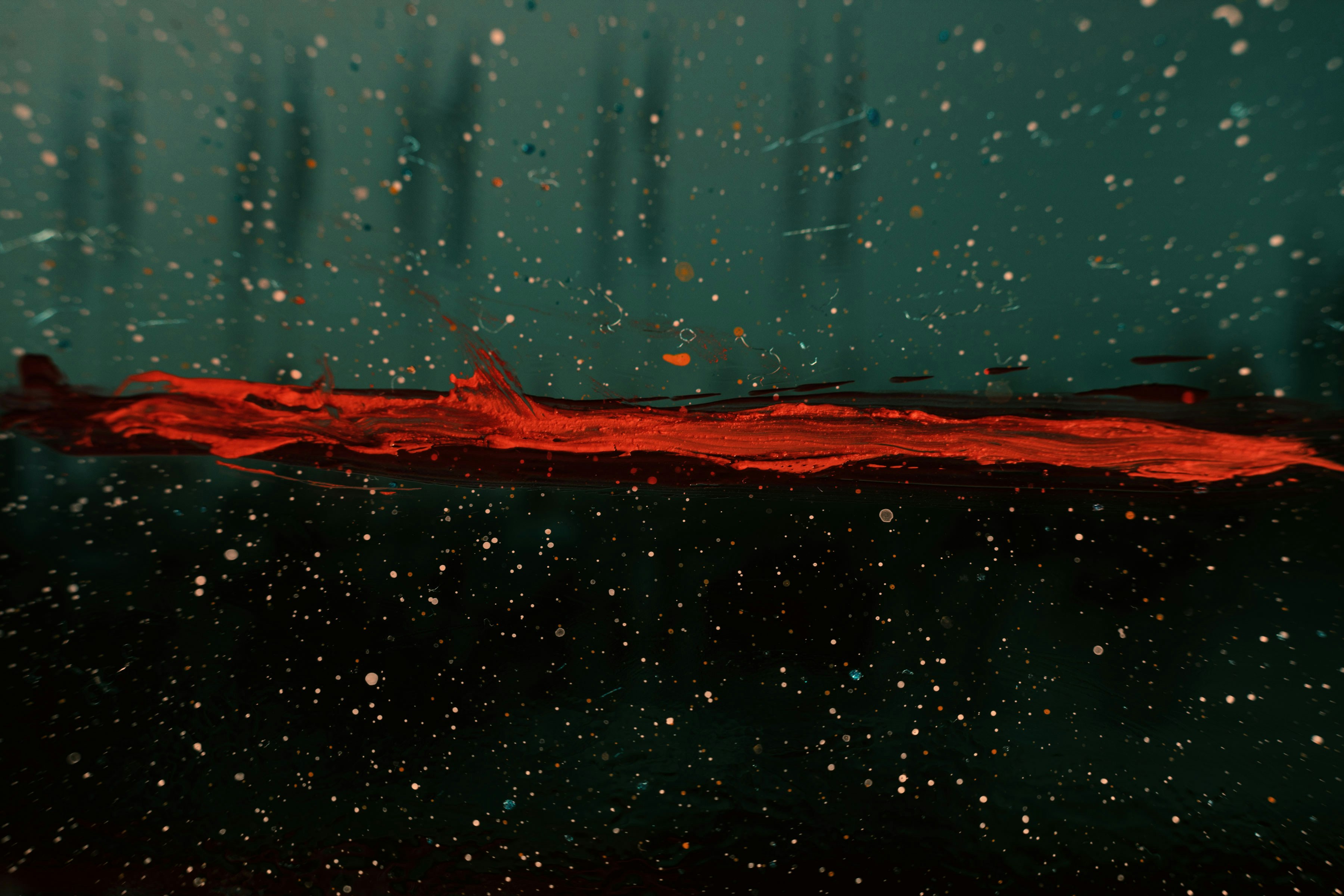 A close up of a red substance on a black surface photo – Free ...