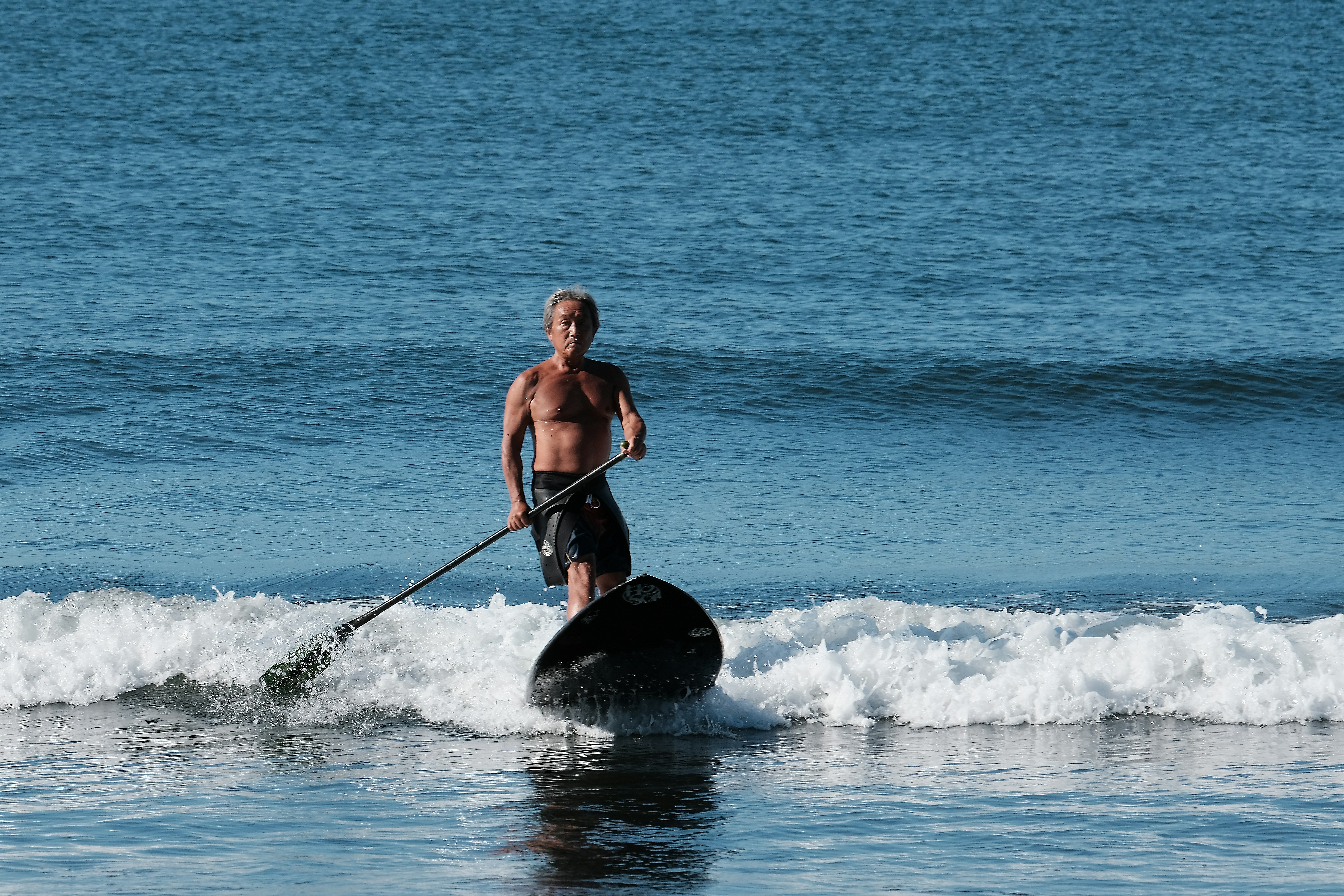 Low Tide Rider: A Solitary Paddleboarder Against the Pacific Blue