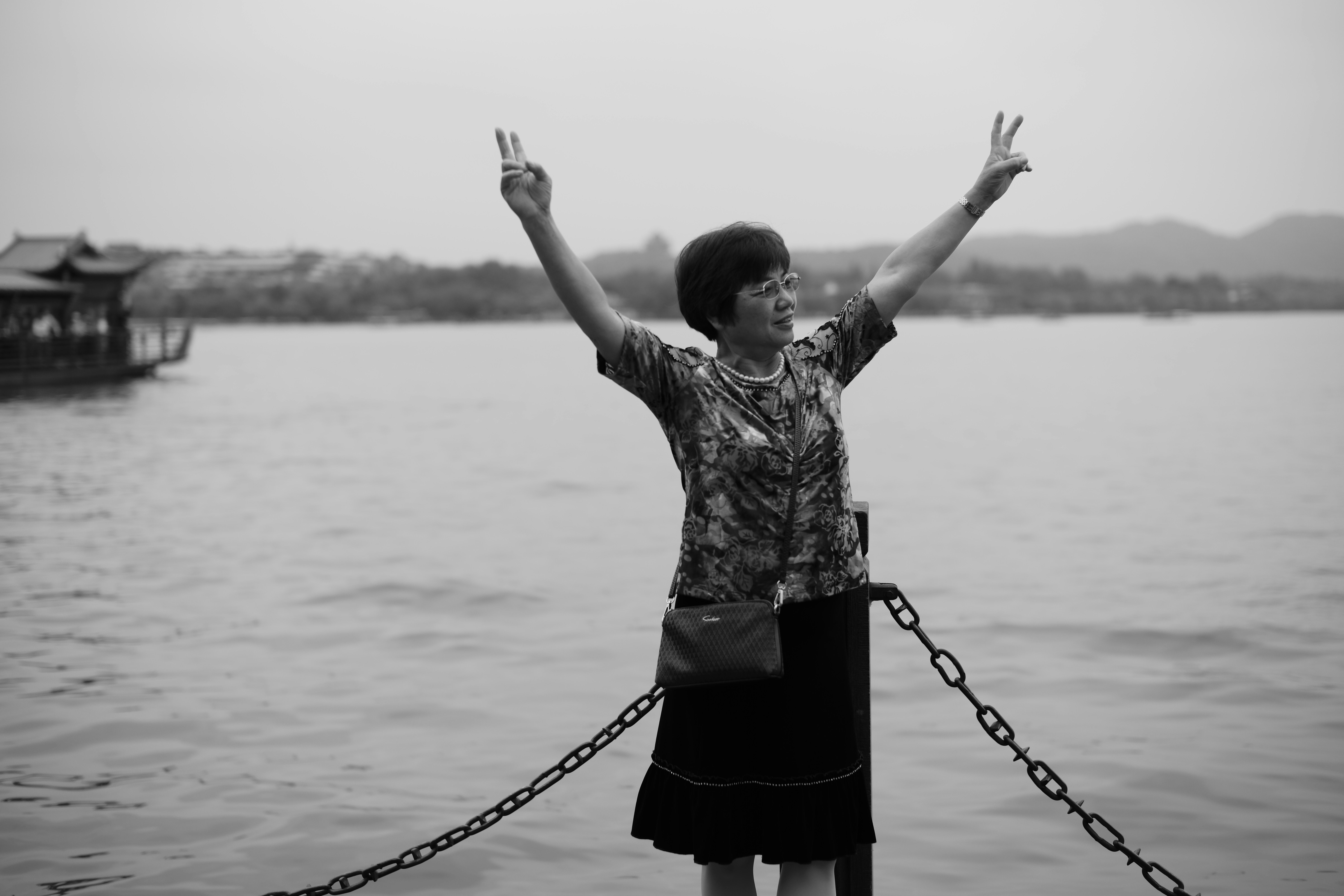 Grayscale photography of woman making peace hand sign while standing ...