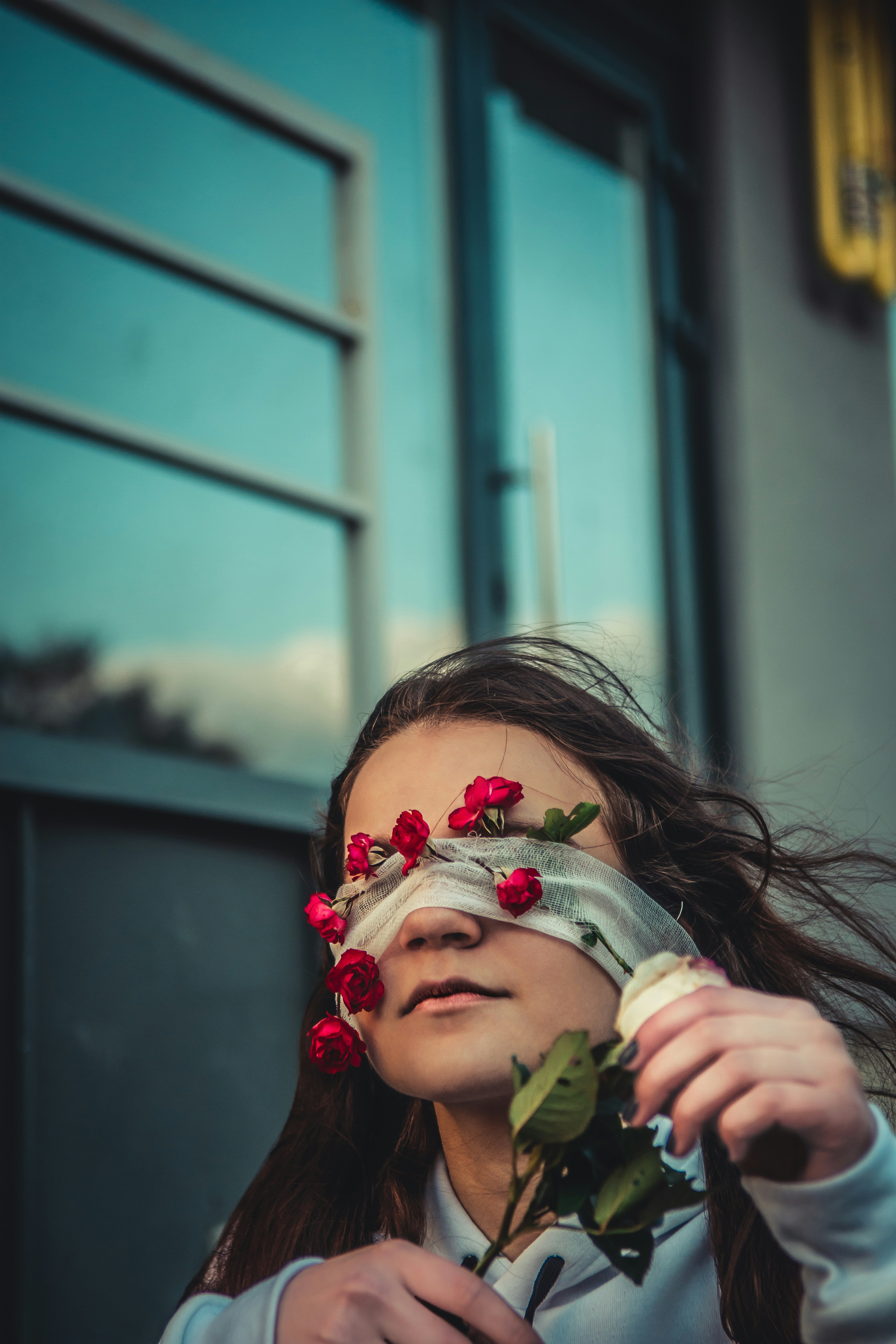 Femme avec un bandeau sur les yeux et des roses rouges sur la pointe ...