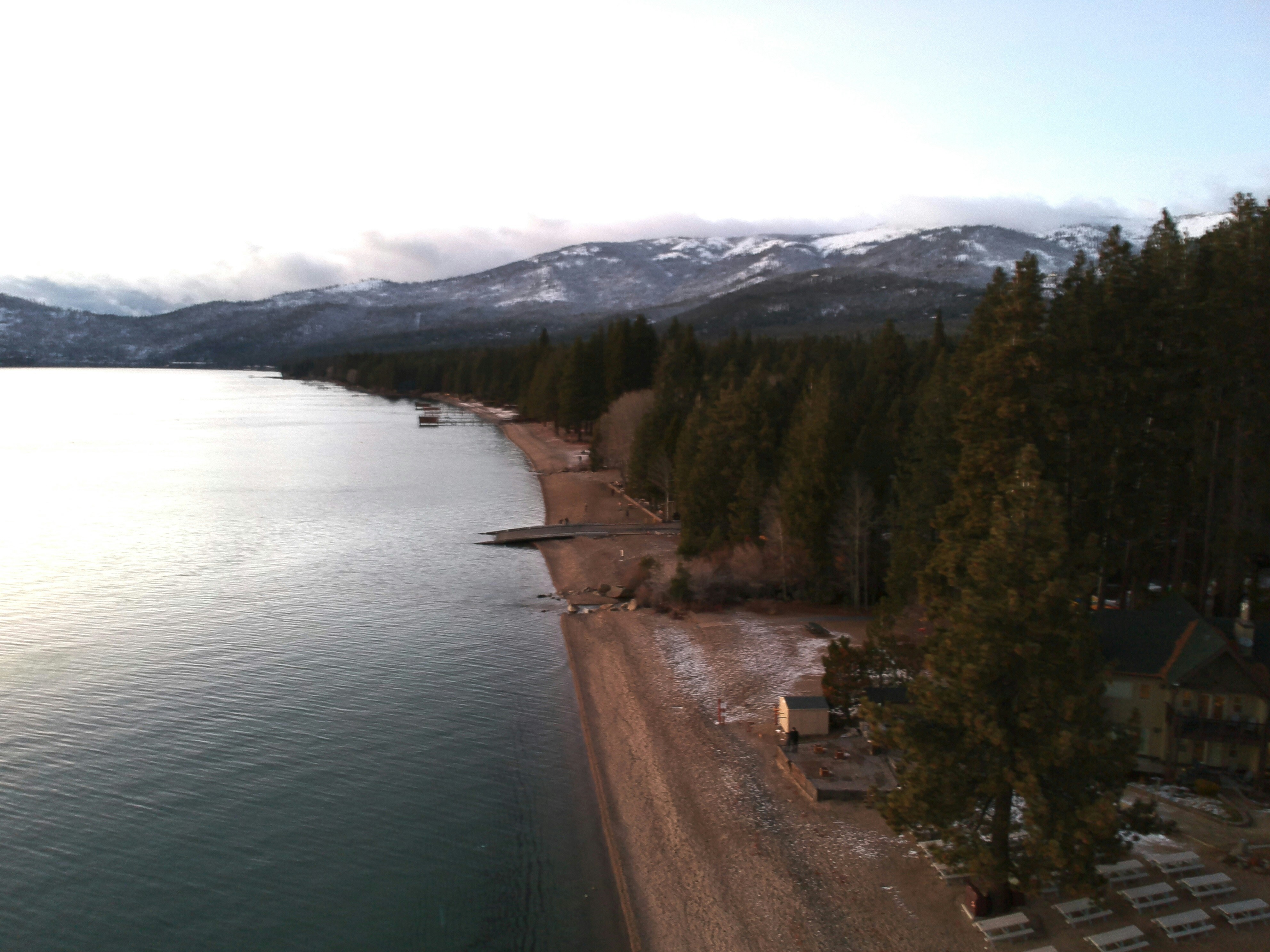 Lakeside Pines at Dusk: Snow-Capped Peaks Beyond a Quiet Shore