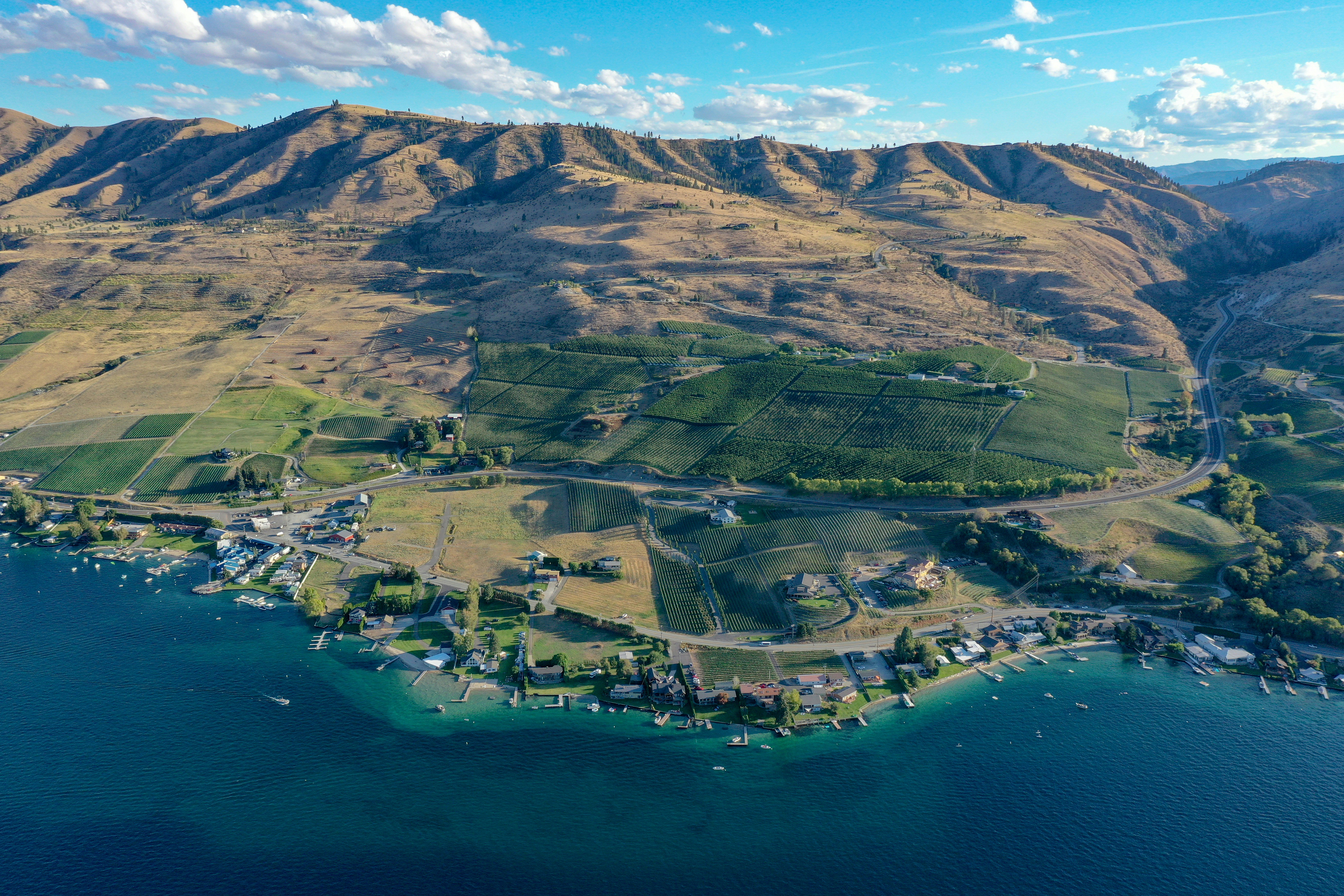 Coastal Terraces and Village Crescent Under Mountain Sun