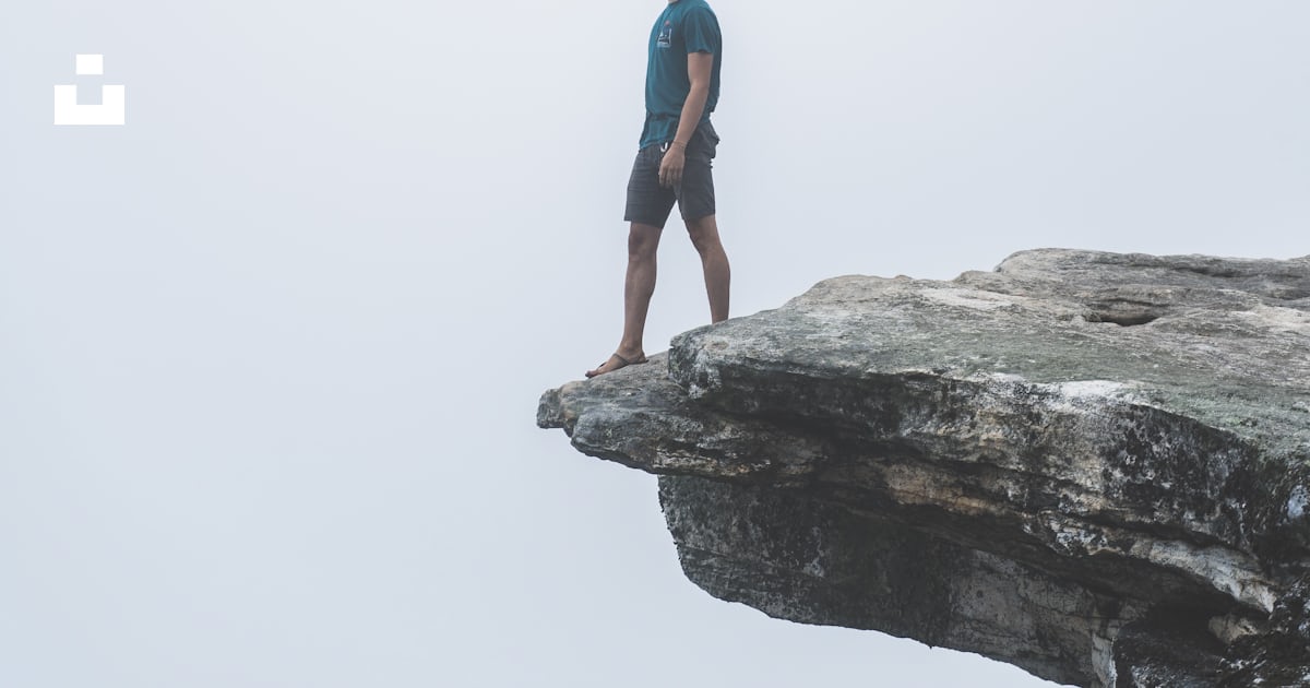 Foto Hombre En Camiseta Azul De Pie En El Acantilado Imagen Gris