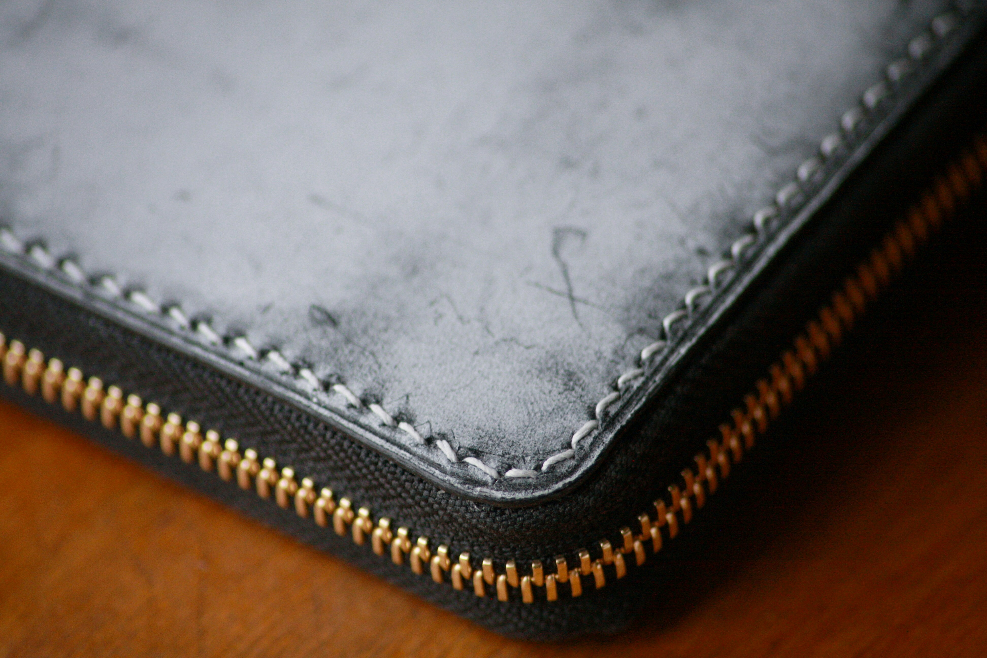 Edge of Precision: Gold Zipper Framing a Gray Leather Corner
