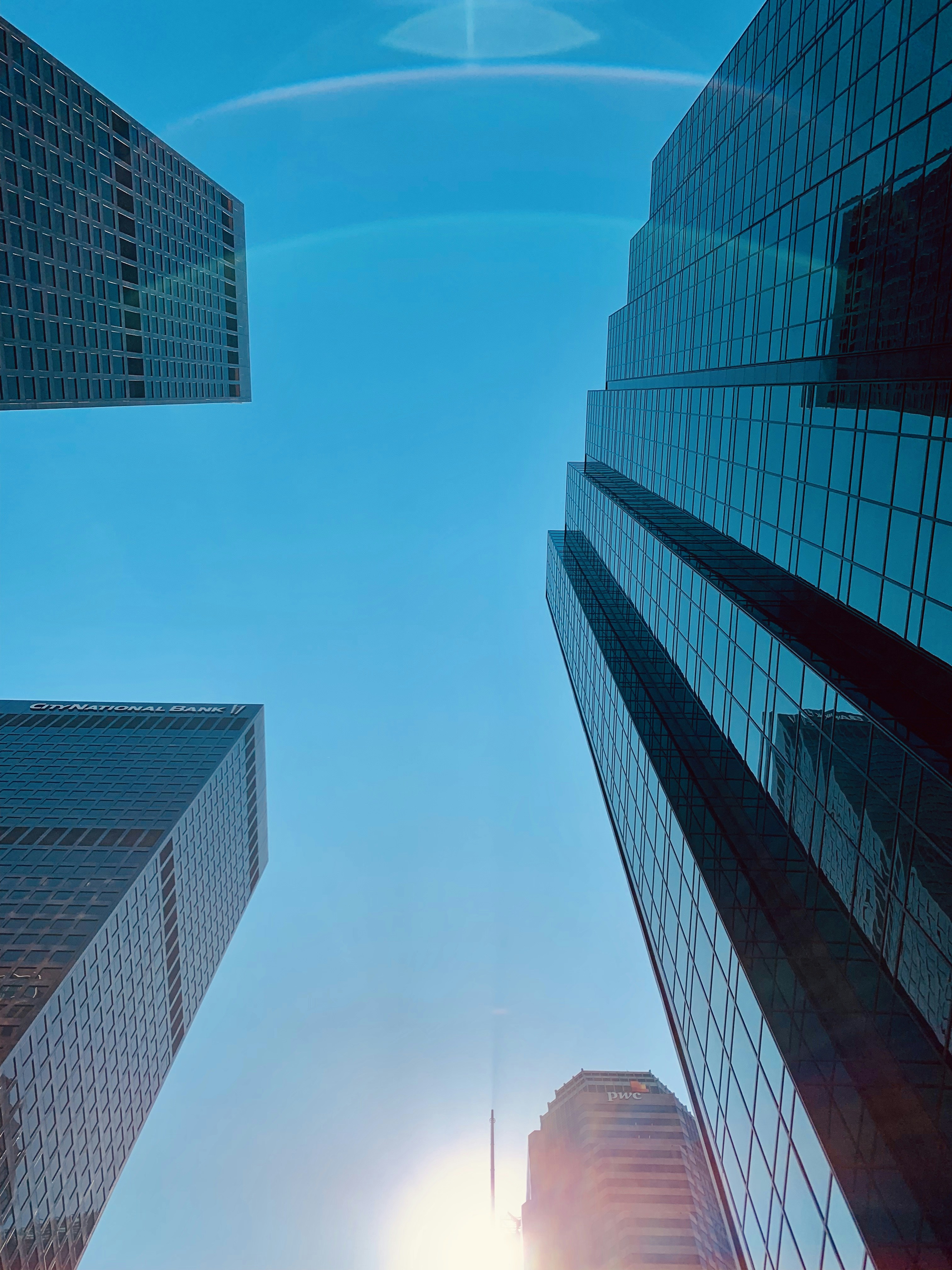 Skyward Glass: Sunlit Facades Between Towering Giants