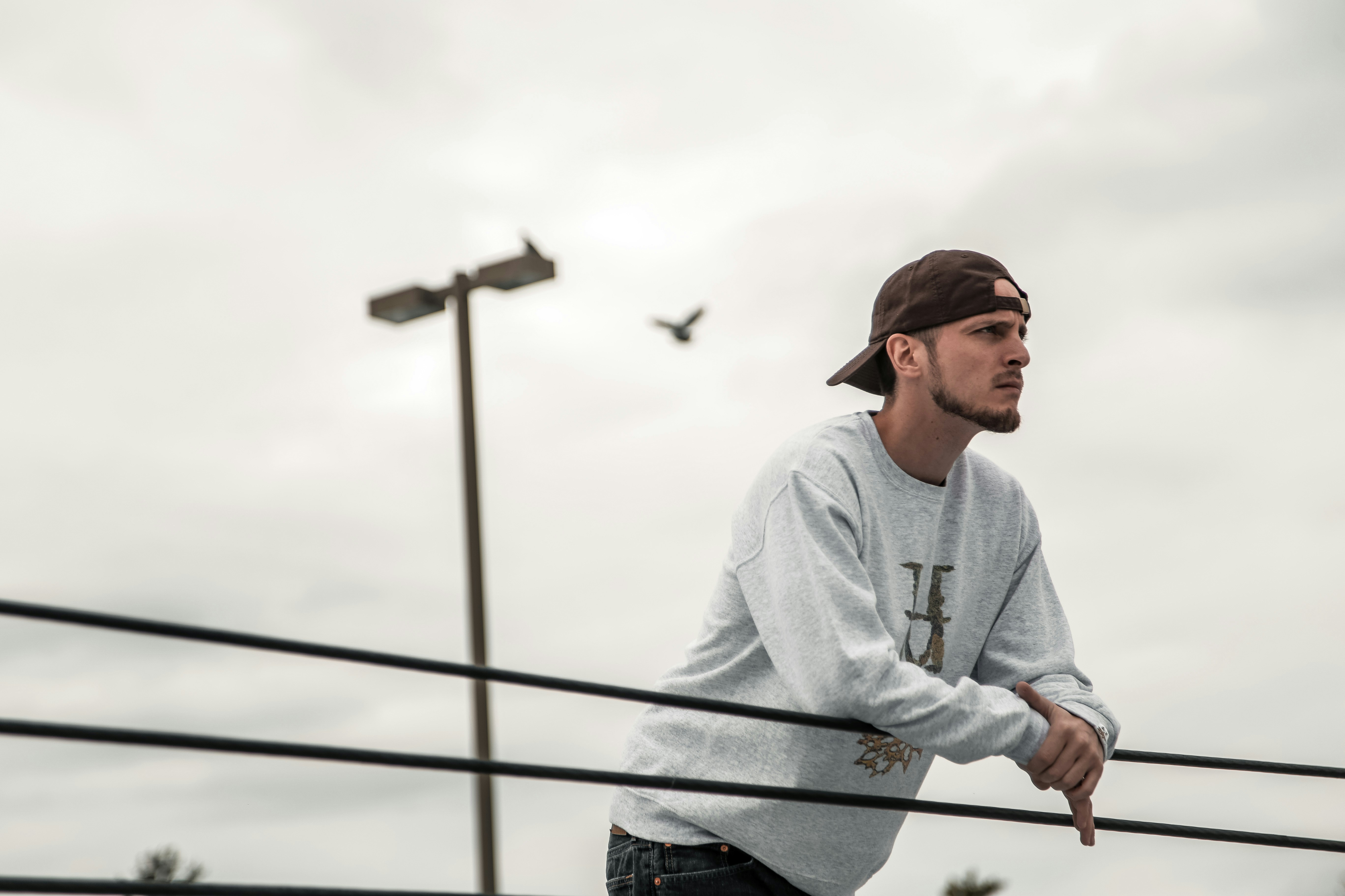 Foto Hombre apoyado en la barandilla – Imagen Marrón gratis en Unsplash