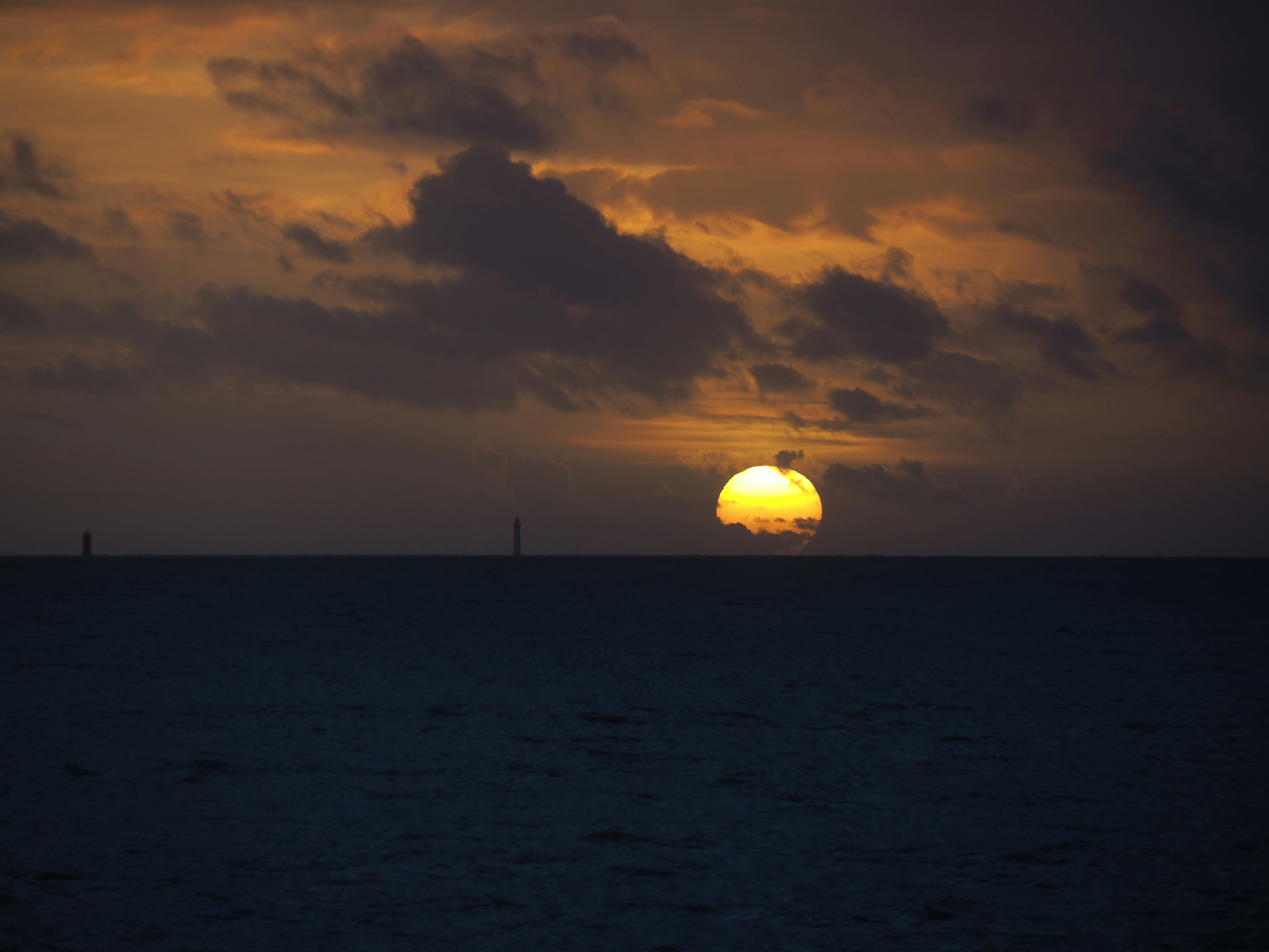 Horizon Fire: Sun Dips Behind a Calm Sea