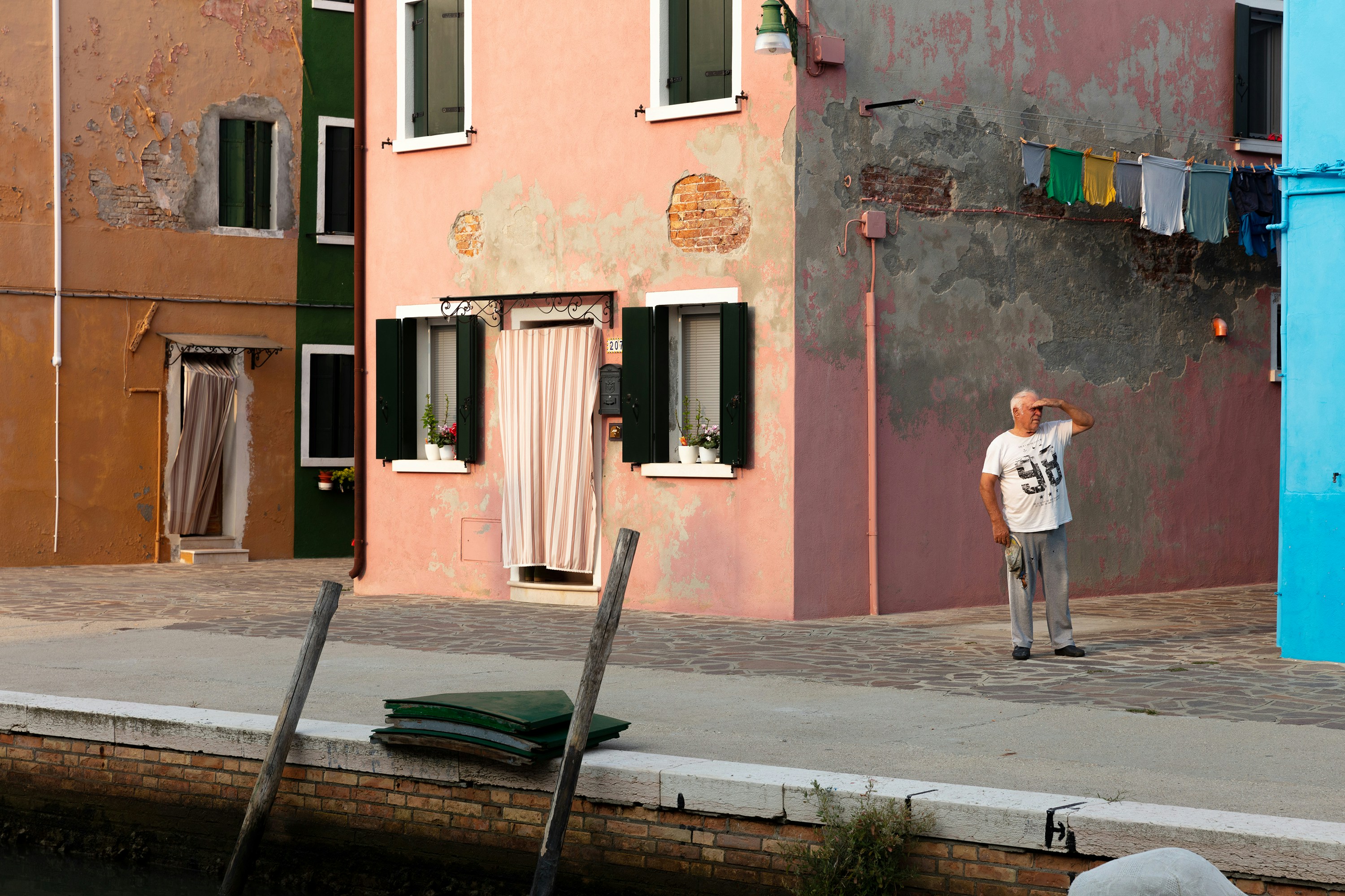 Man standing beside red building photo – Free Burano Image on Unsplash
