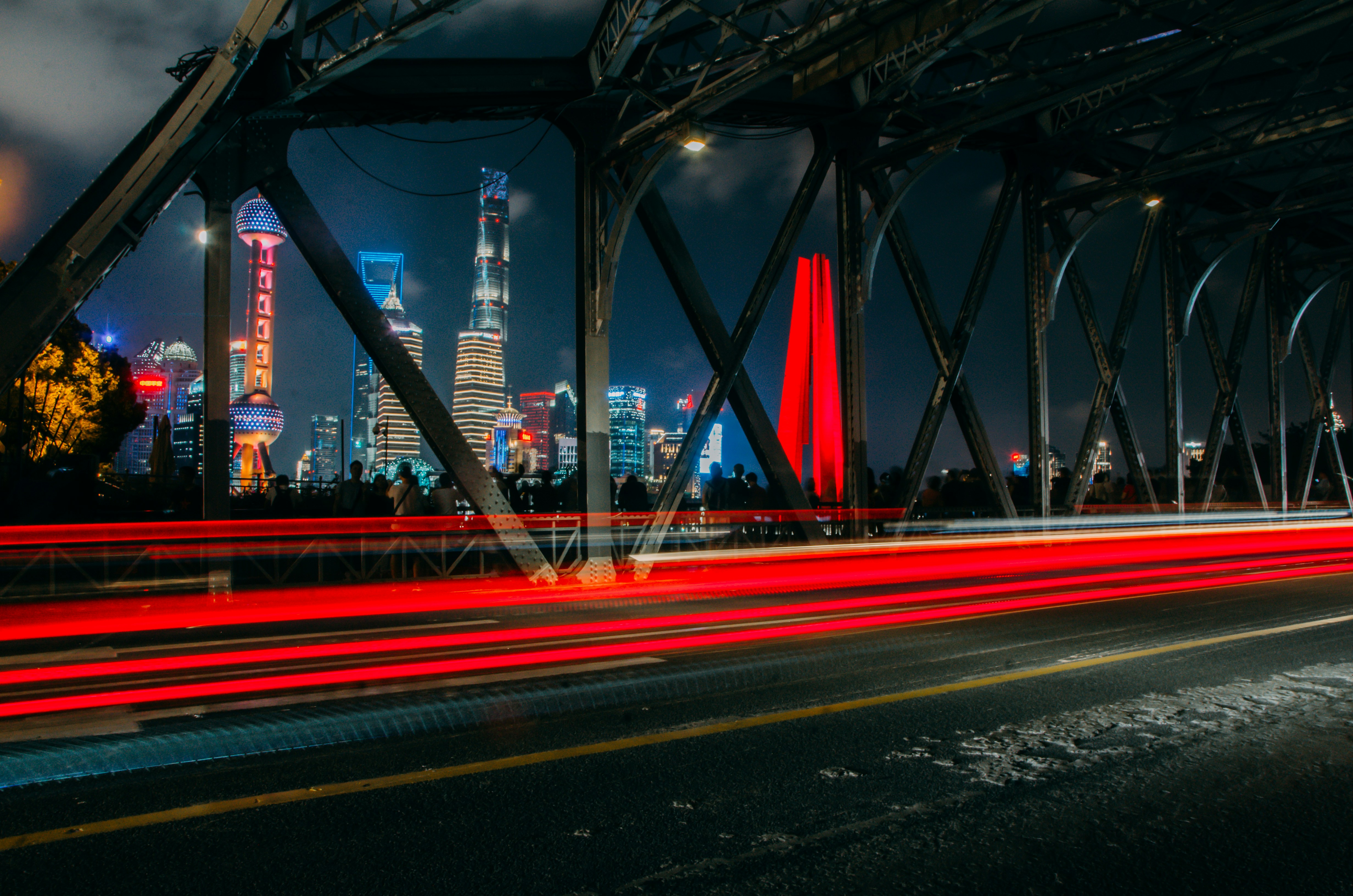 Crimson Trails Over the Night Bridge Amid Neon Skyline
