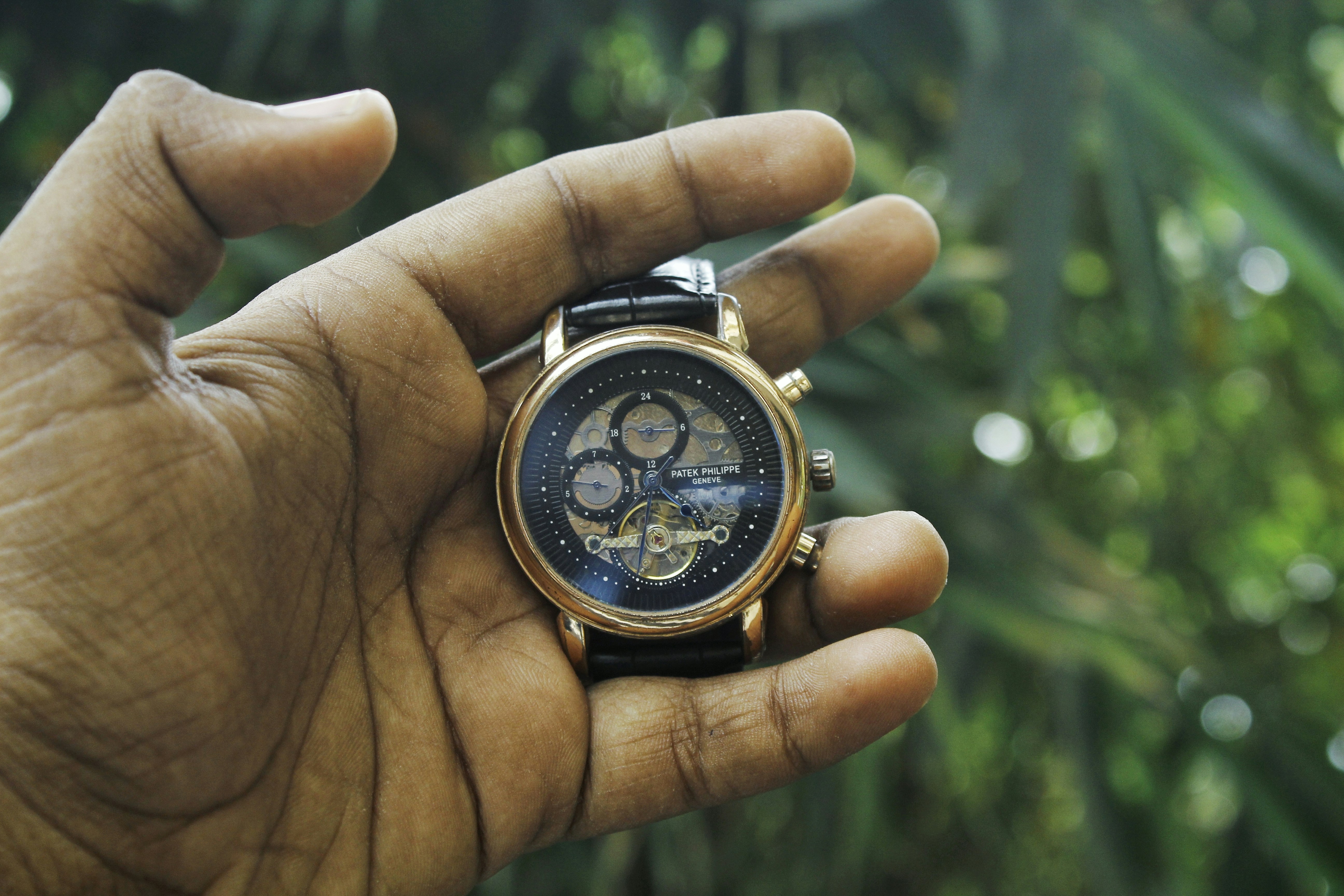 gold-colored chronograph watch with black leather band