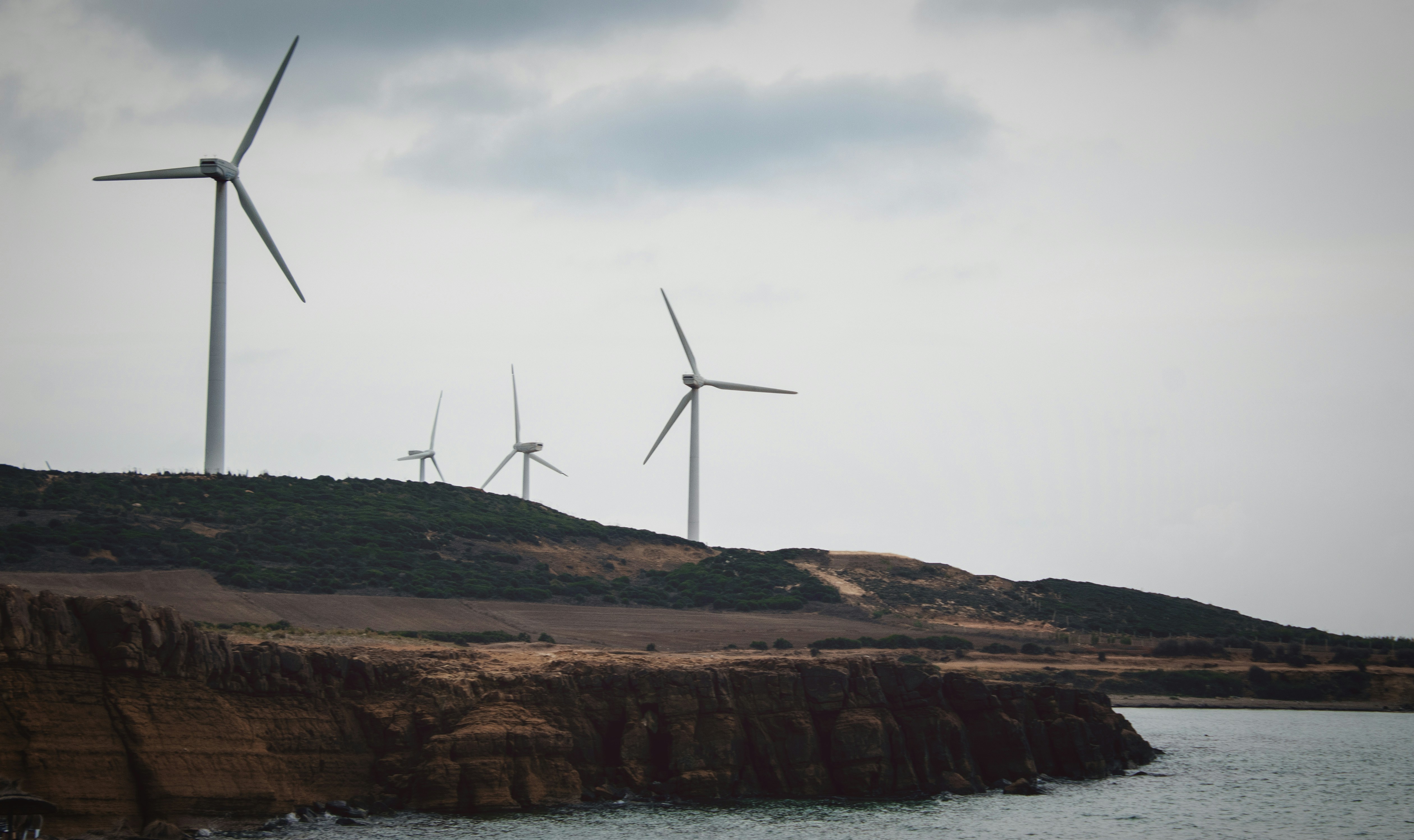 Wind Giants Over a Worn Coastal Clifftop