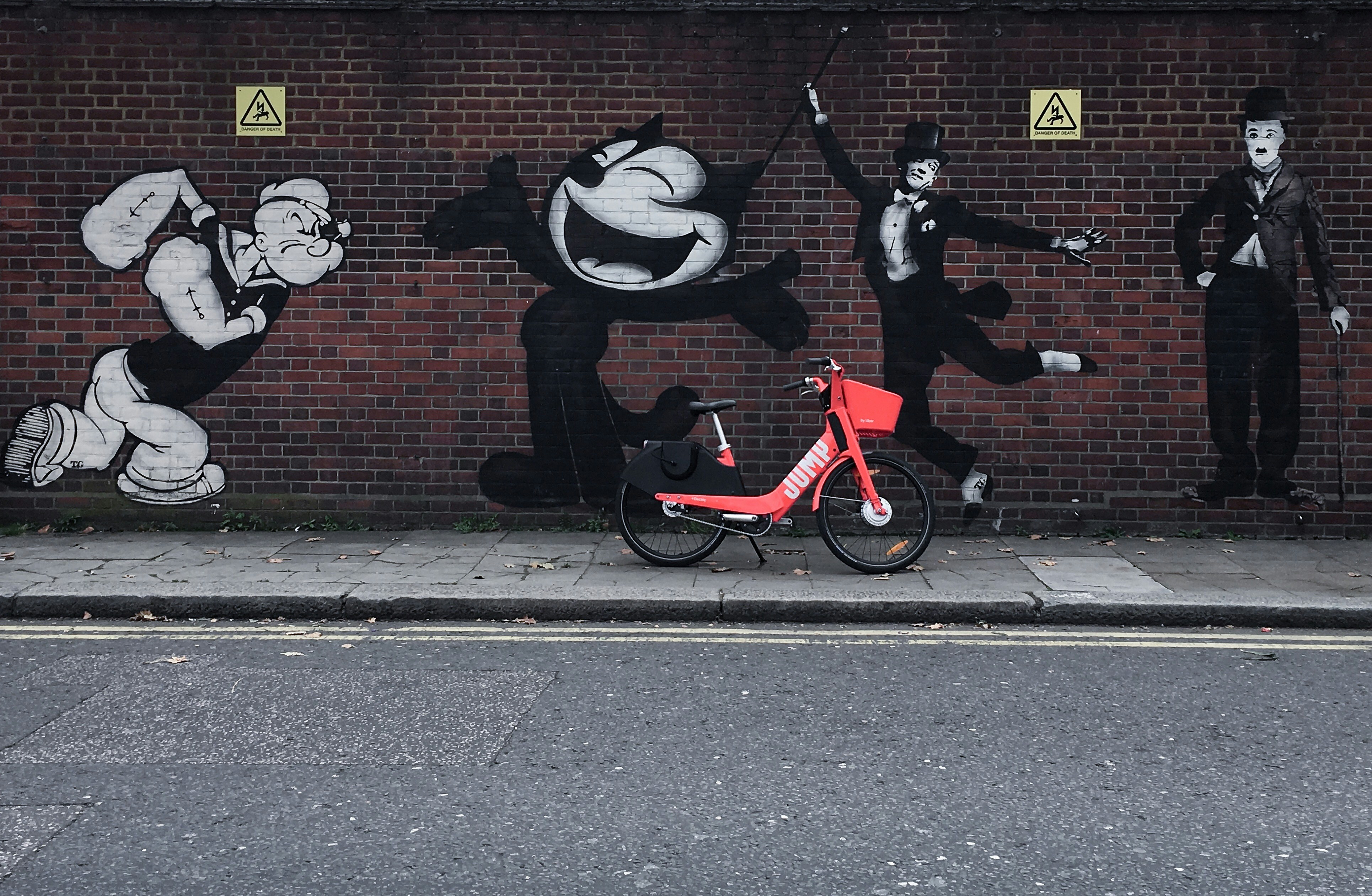 Crimson Commuter Stands Out Against a Monochrome Mural
