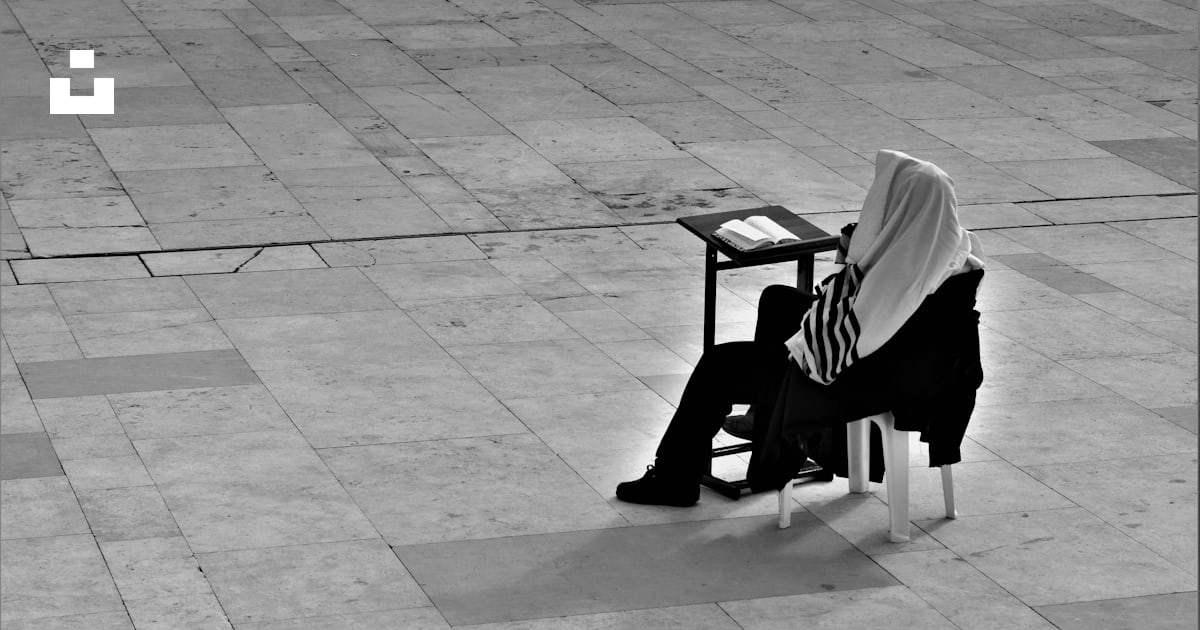 Foto En Escala De Grises De Una Persona Sentada En Una Silla De