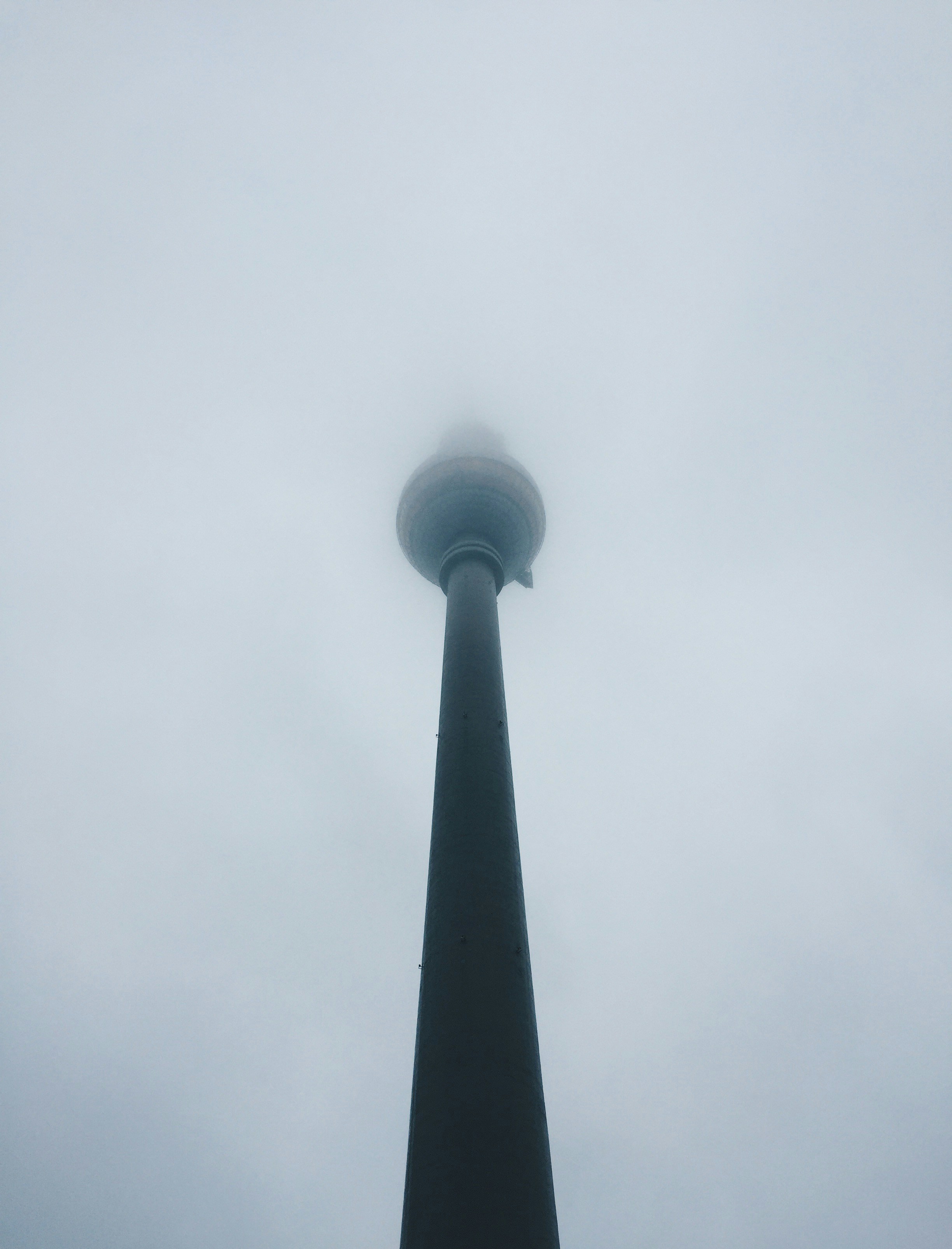 A towering structure disappearing into a blanket of fog, evoking a sense of mystery and isolation.