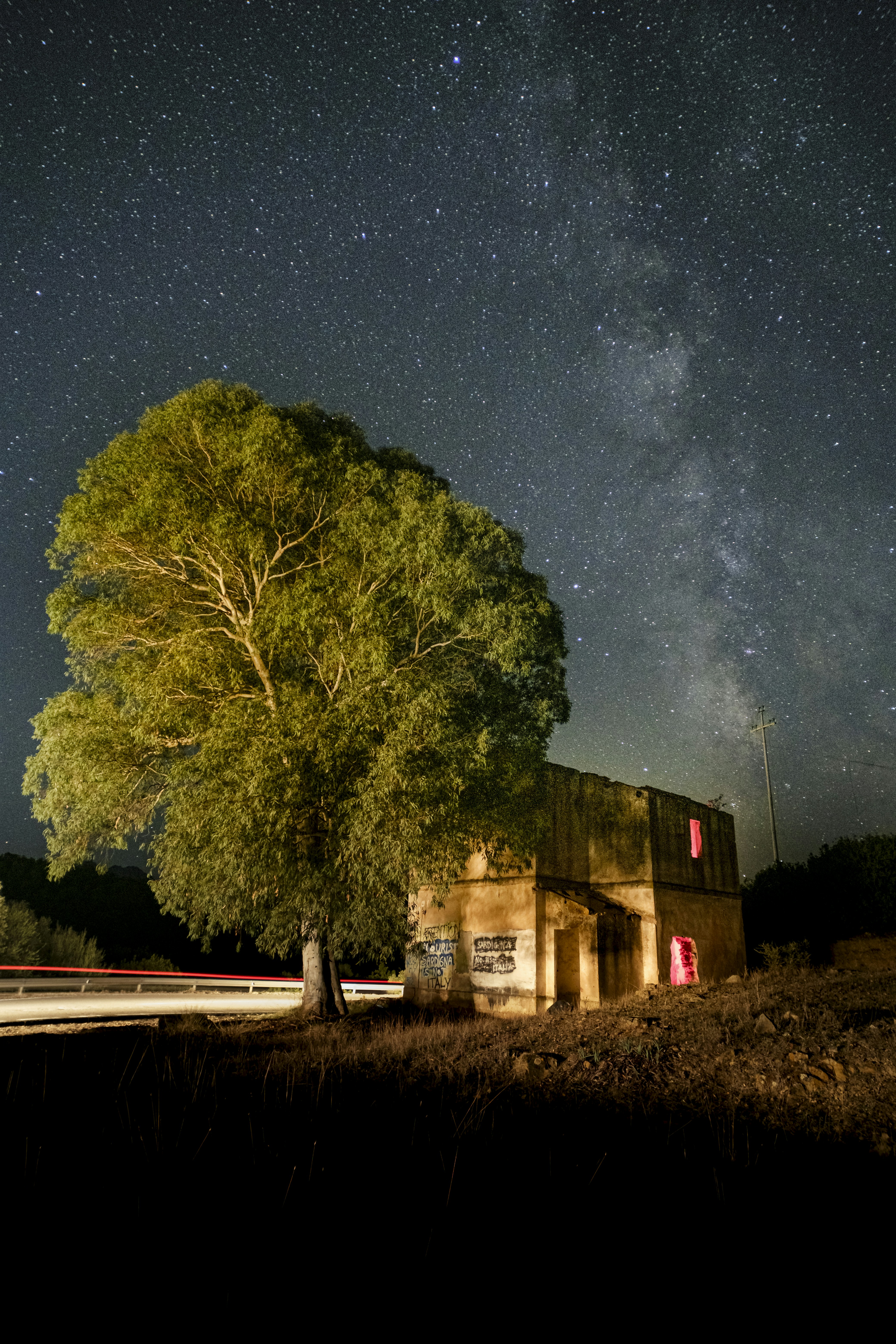 Milky Way Over a Lone Tree and a Weathered Blockhouse