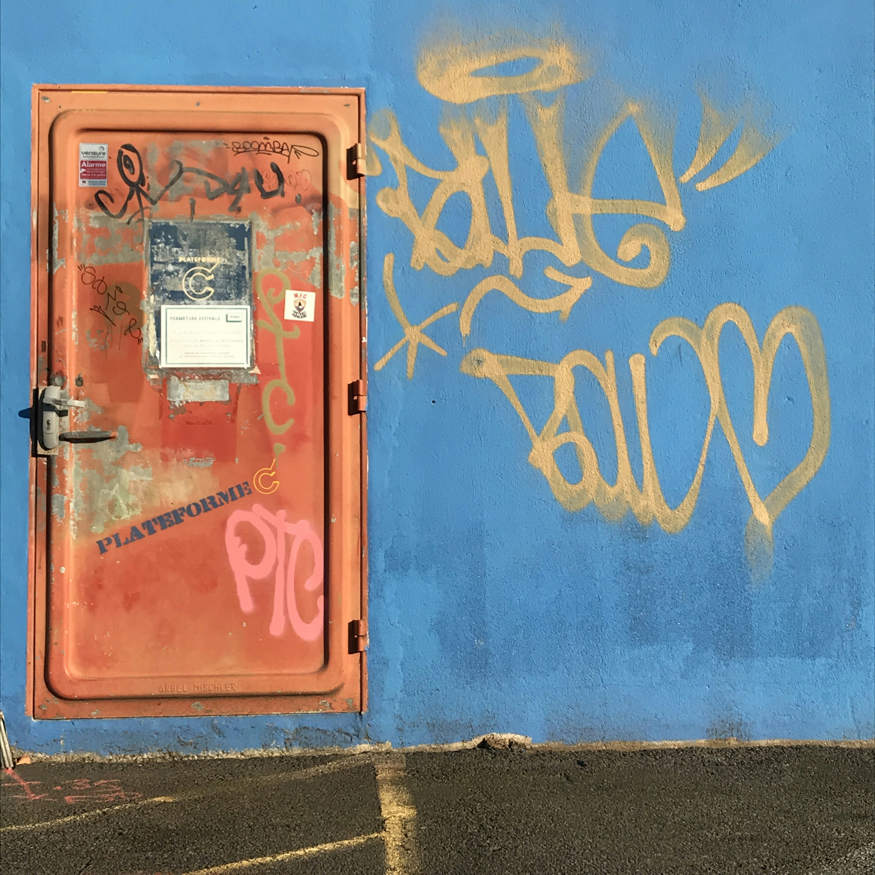 Orange Door Against blue Graffitied Wall
