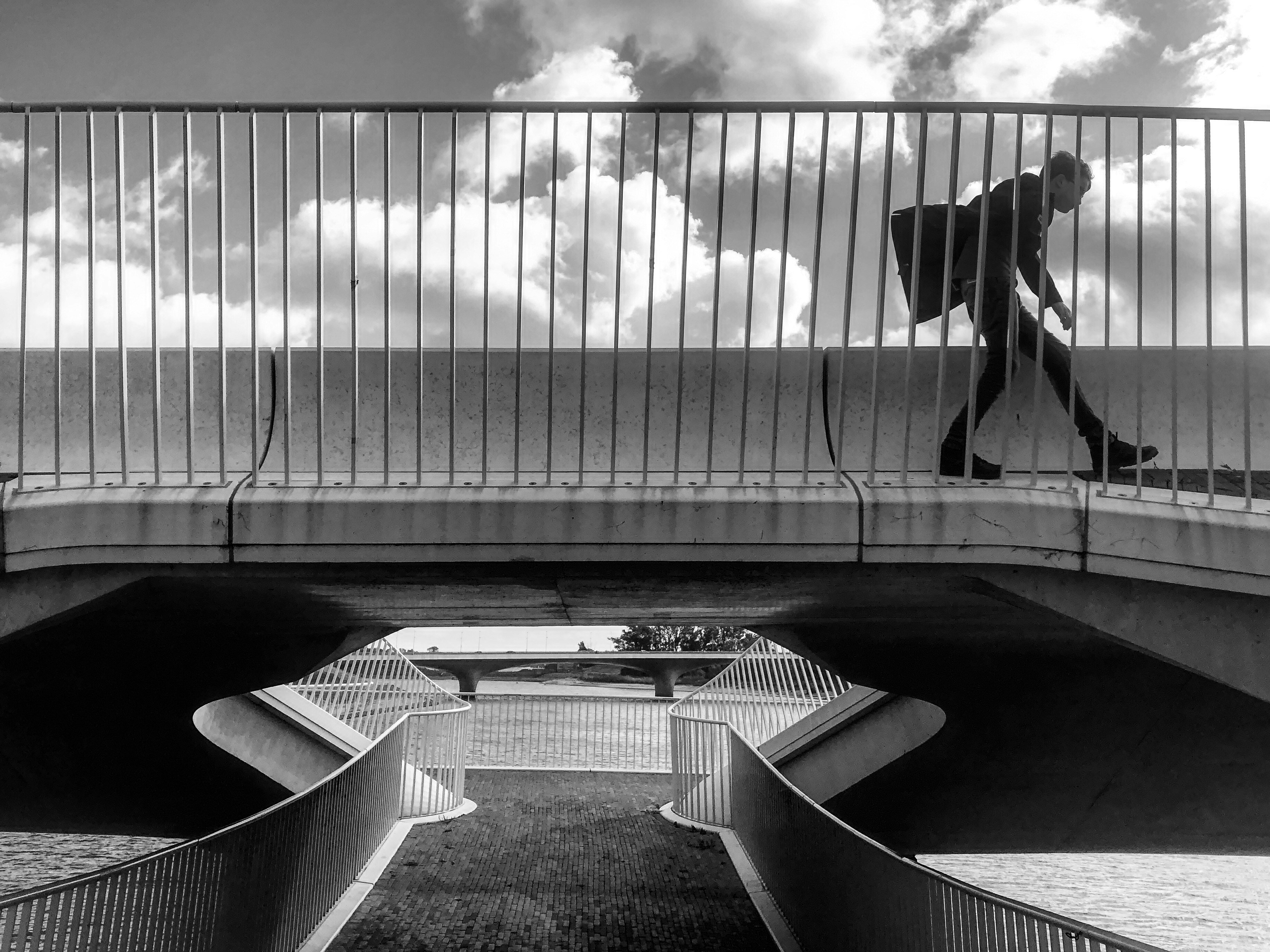 Grayscale photo of man on bridge photo – Free Grey Image on Unsplash