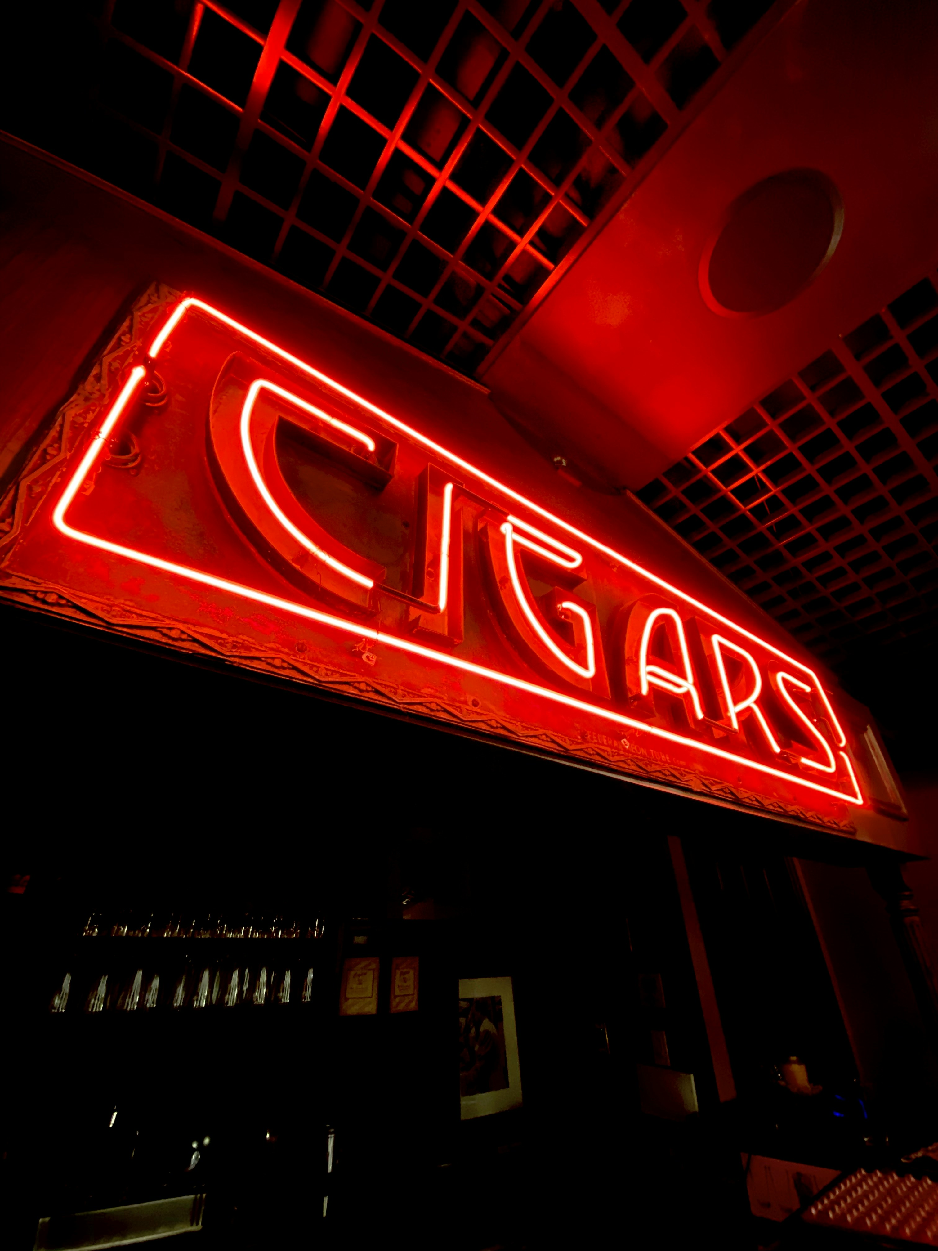 Crimson Neon Over a Cigars Sign