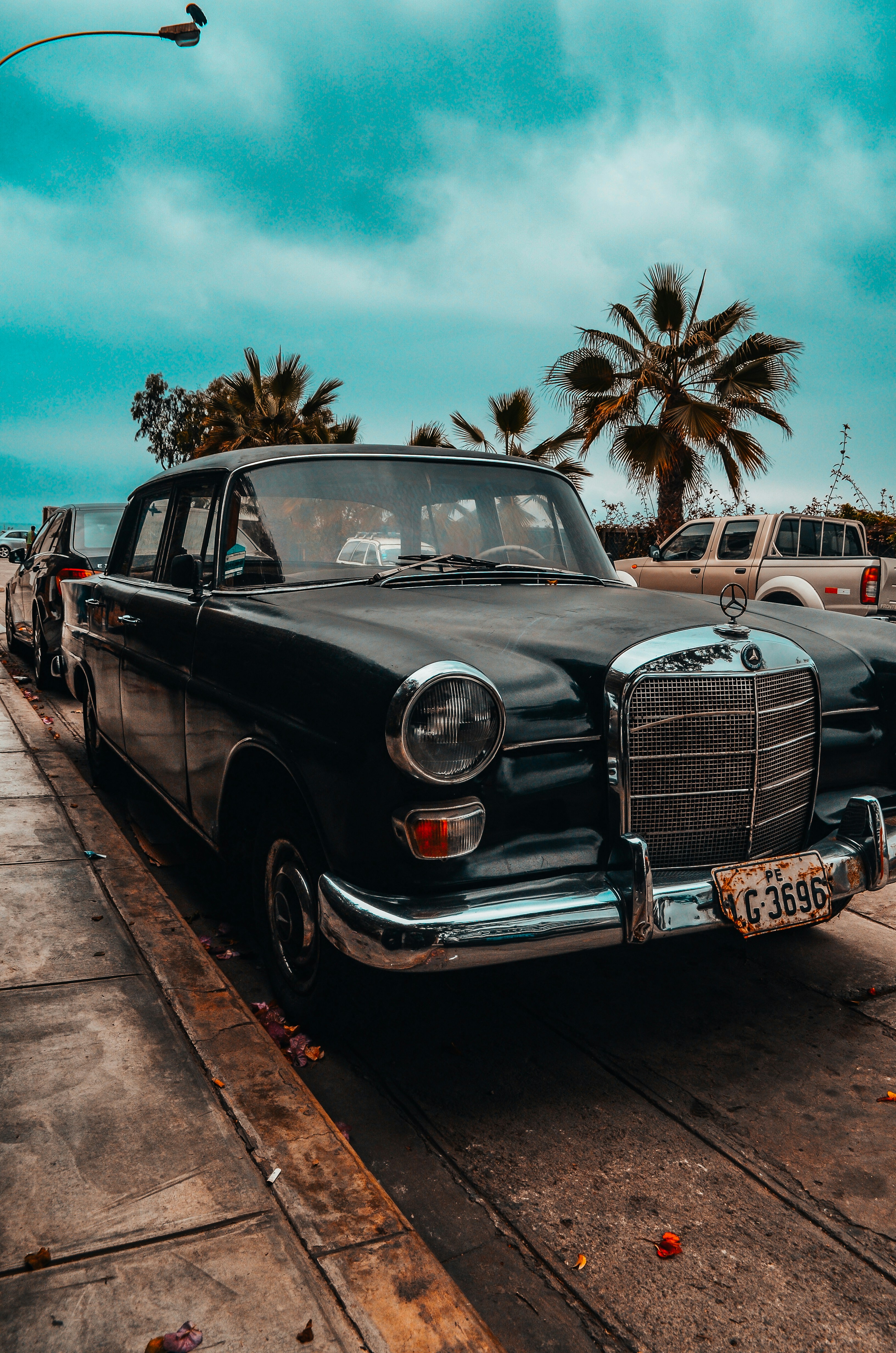 Chrome and Palm Shadows: A California Classic Mercedes on a Teal Sky Street