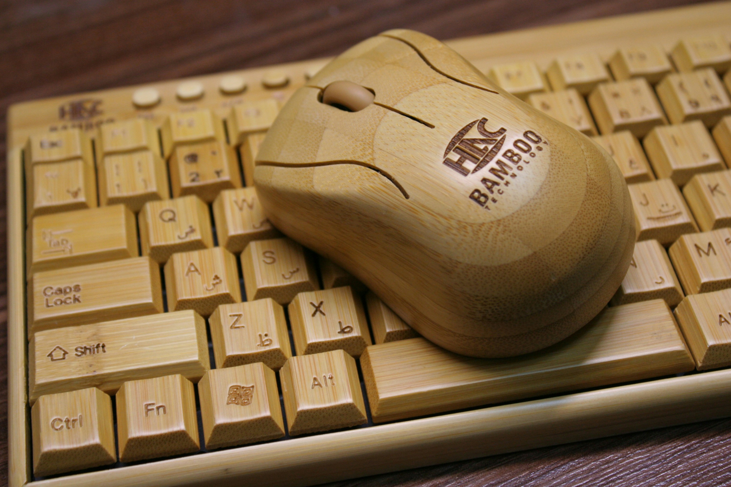 Wooden carved computer mouse rests atop a beige keyboard, showcasing natural grain and retro styling.