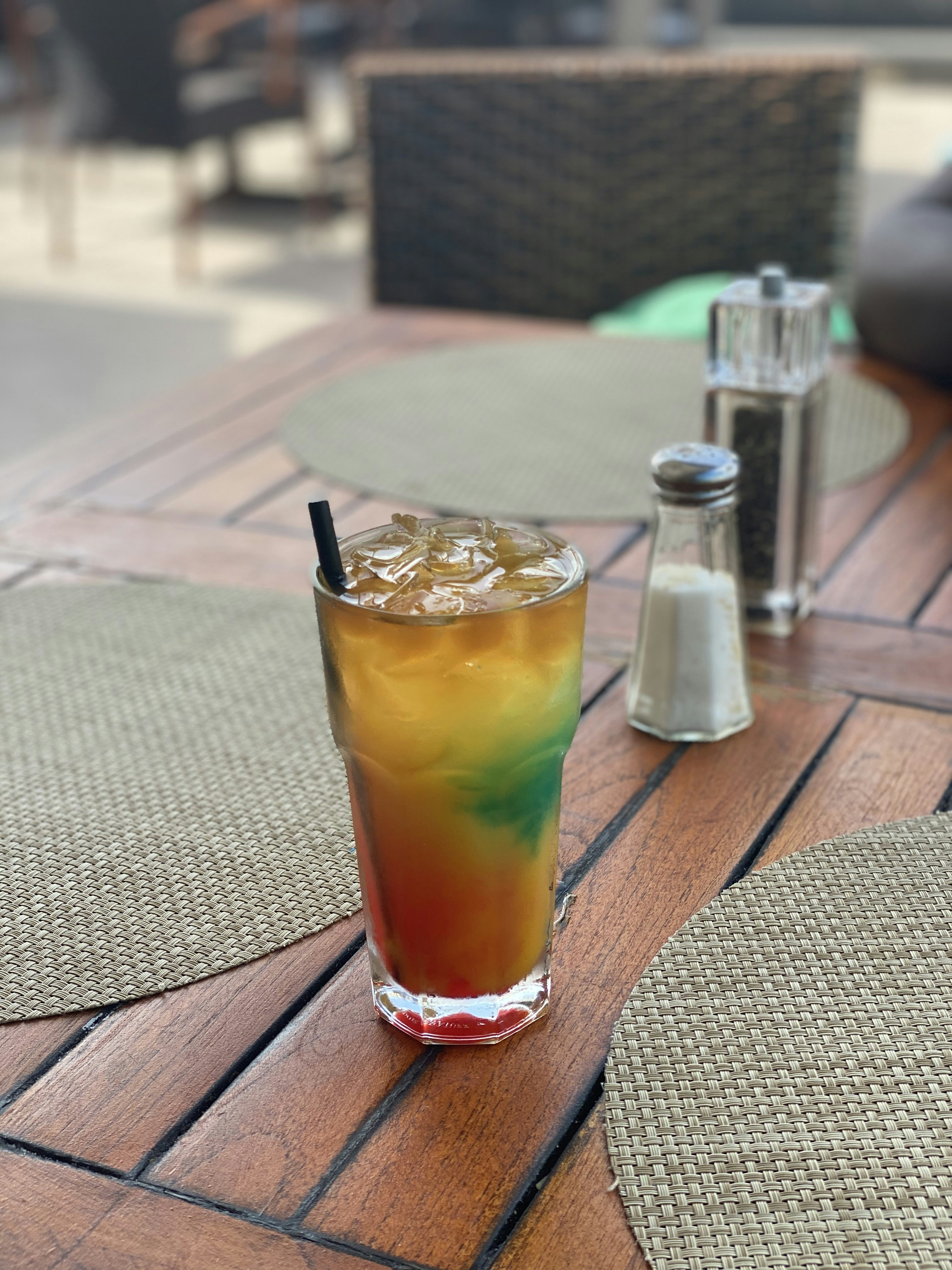 Colorful Tropical Layered Drink on a Wooden Table