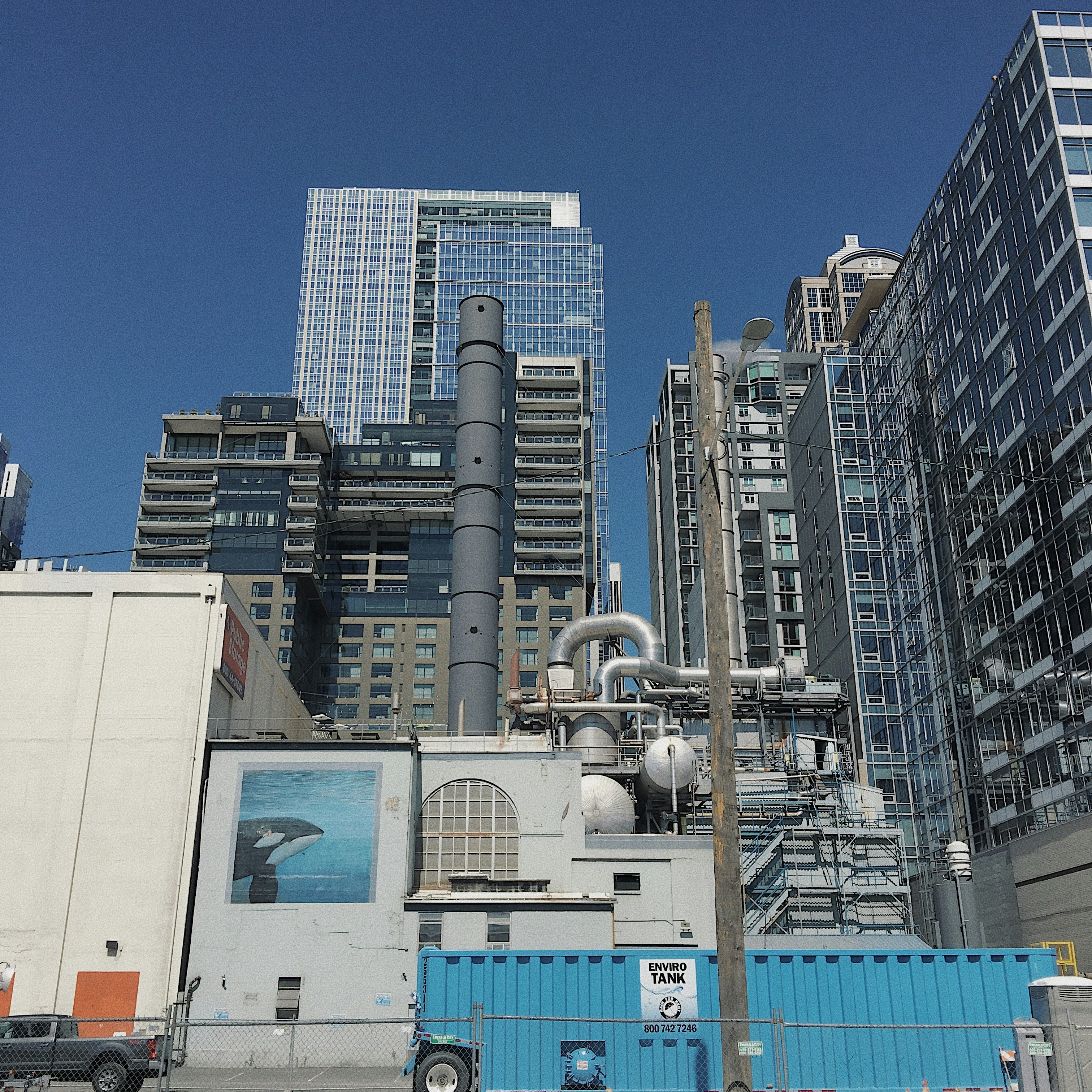 Industrial Conduits Framing a Glass Skyline