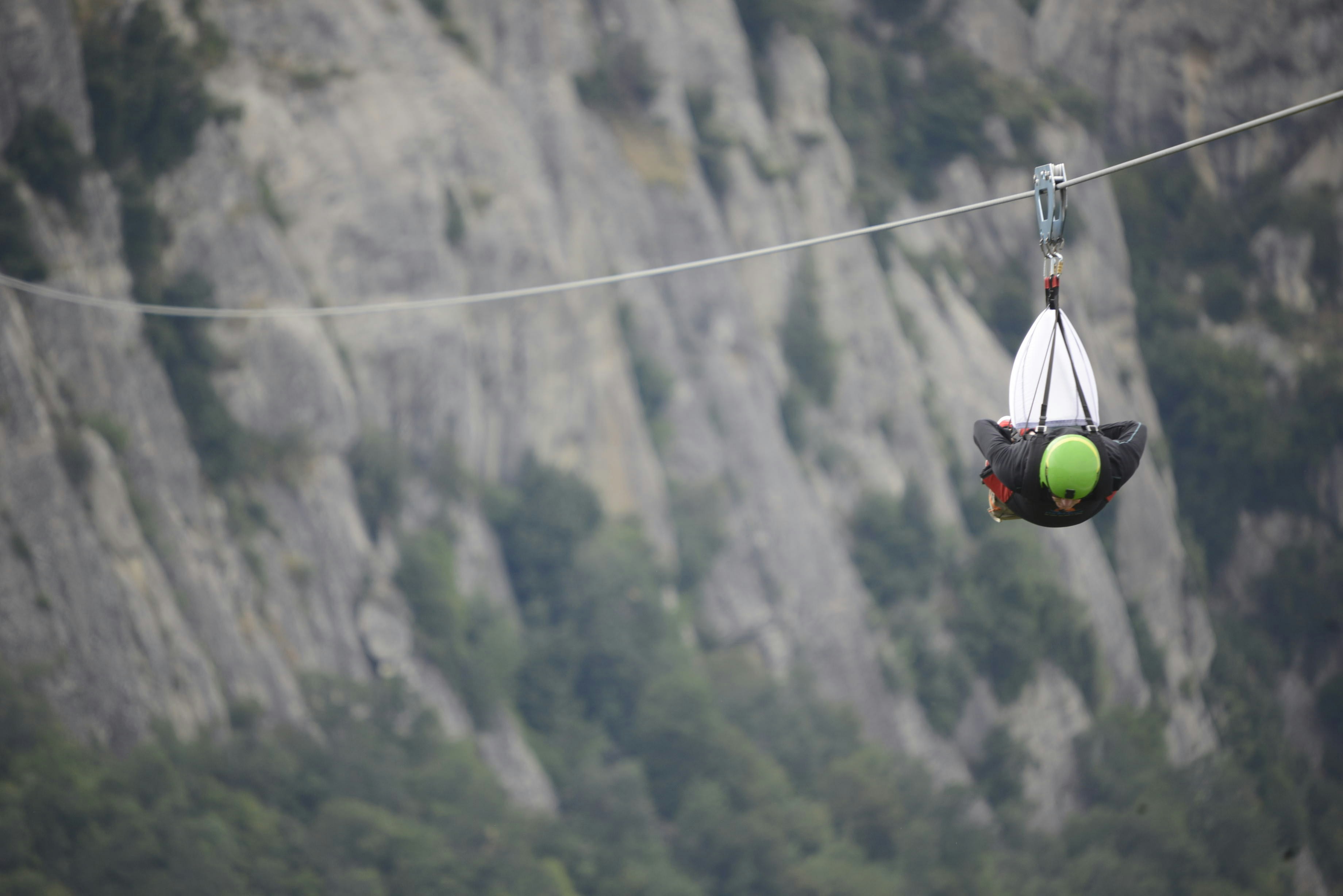 Suspended Silhouette: A lone rider on a cliff-hung cable