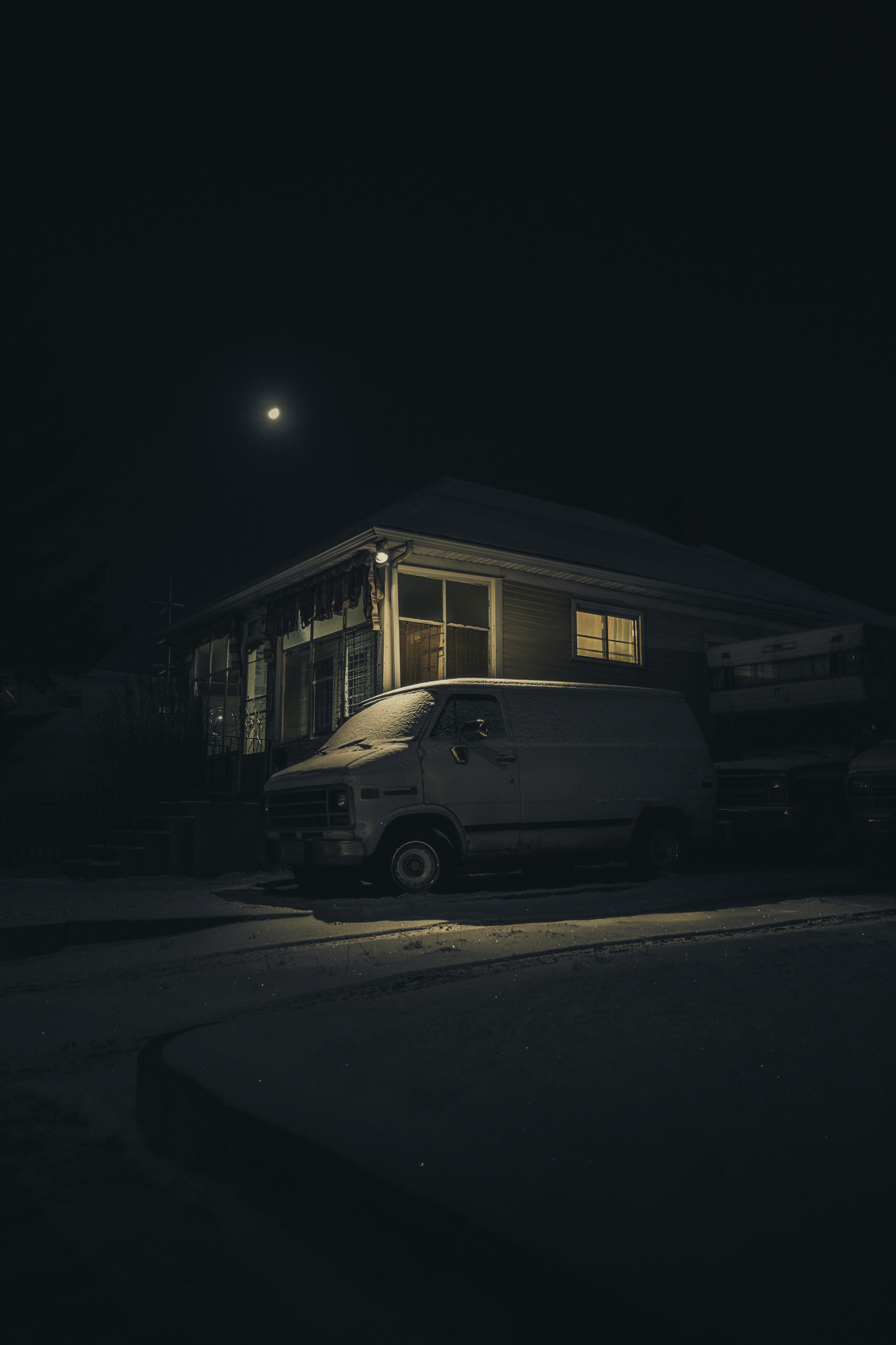 Moonlit Suburb: A Silent Van Beside a Warm Porch Glow