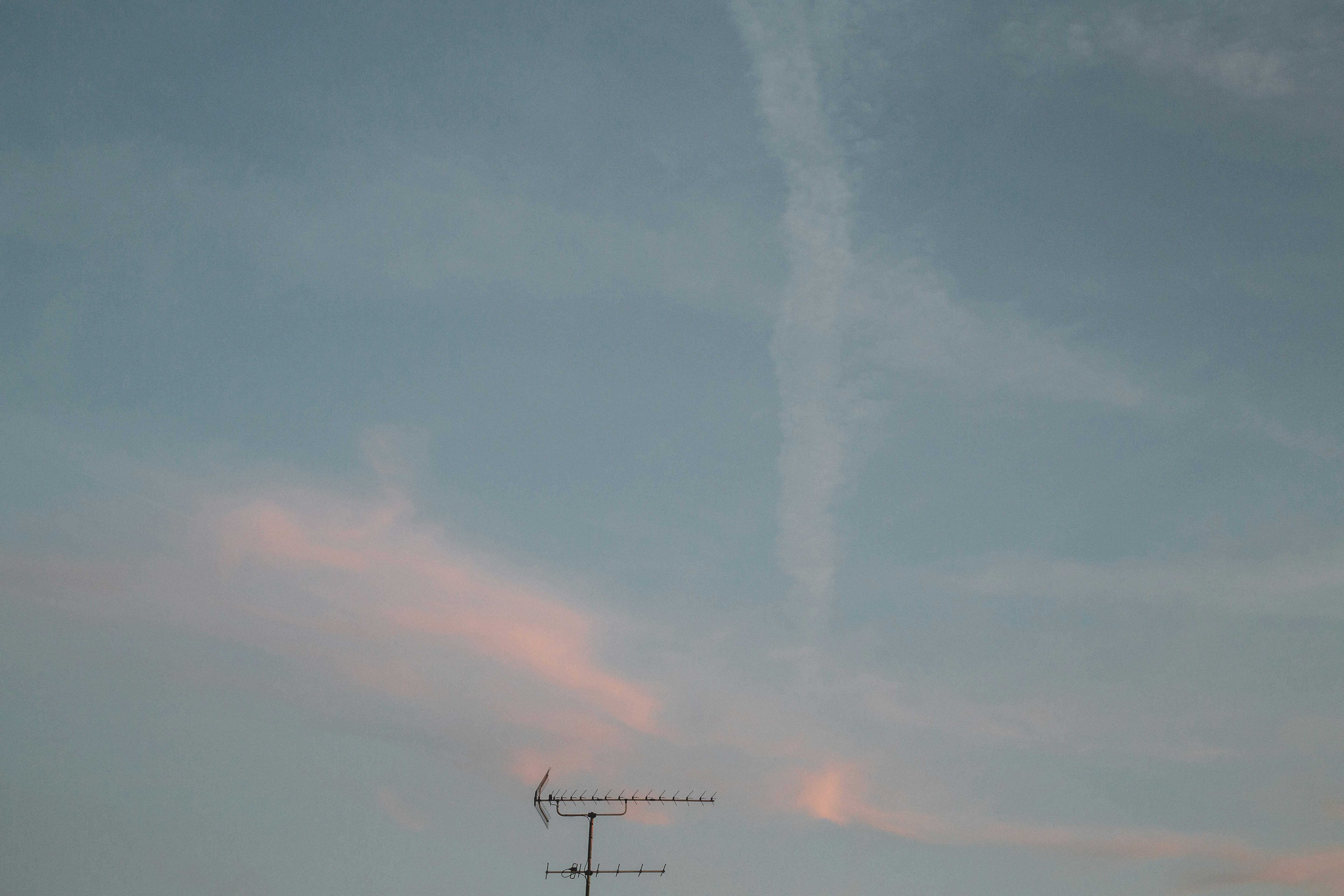 an airplane flying in the sky with a contrail in the background