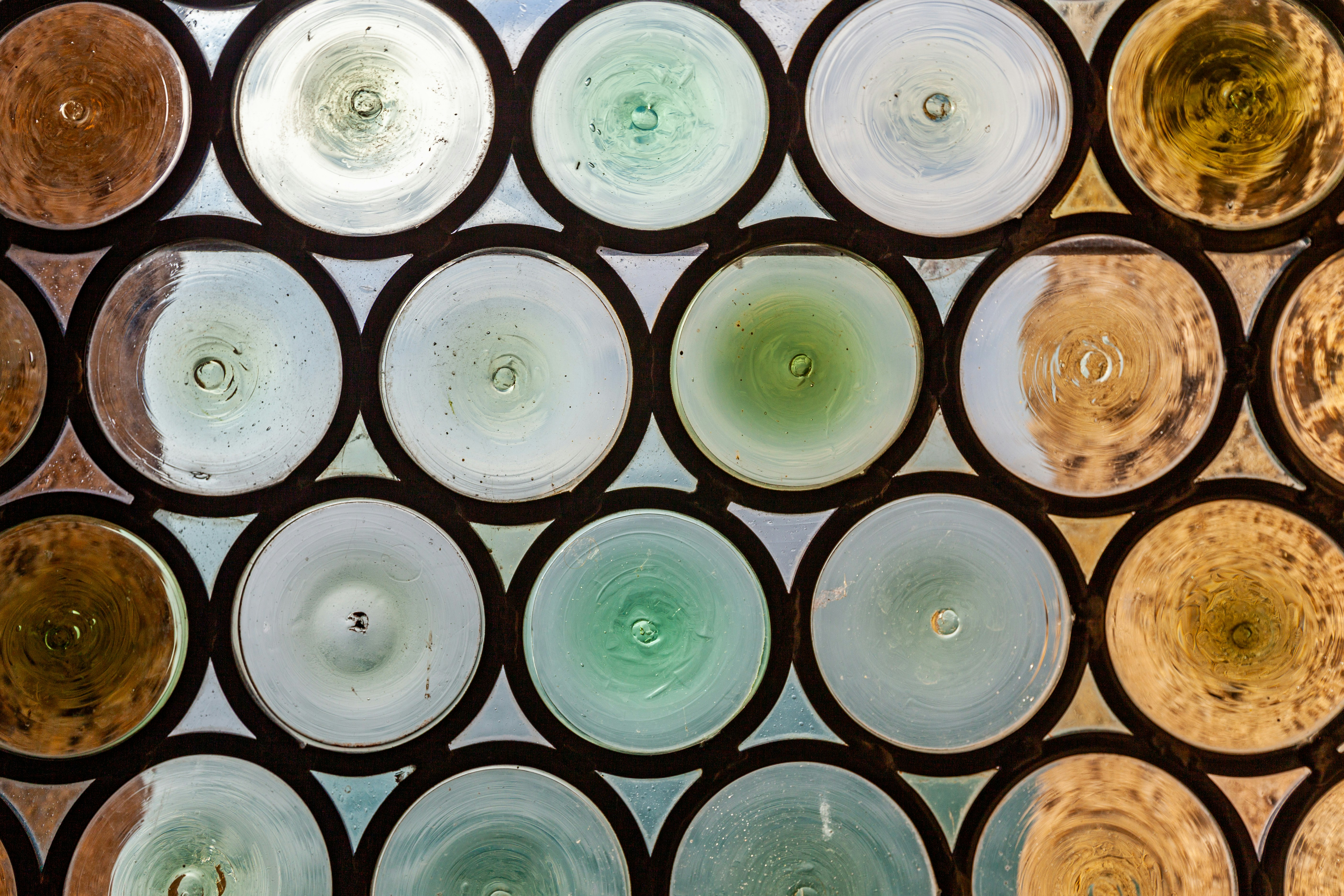 Close-up of a stained glass pattern featuring circular panes in varied earth tones.