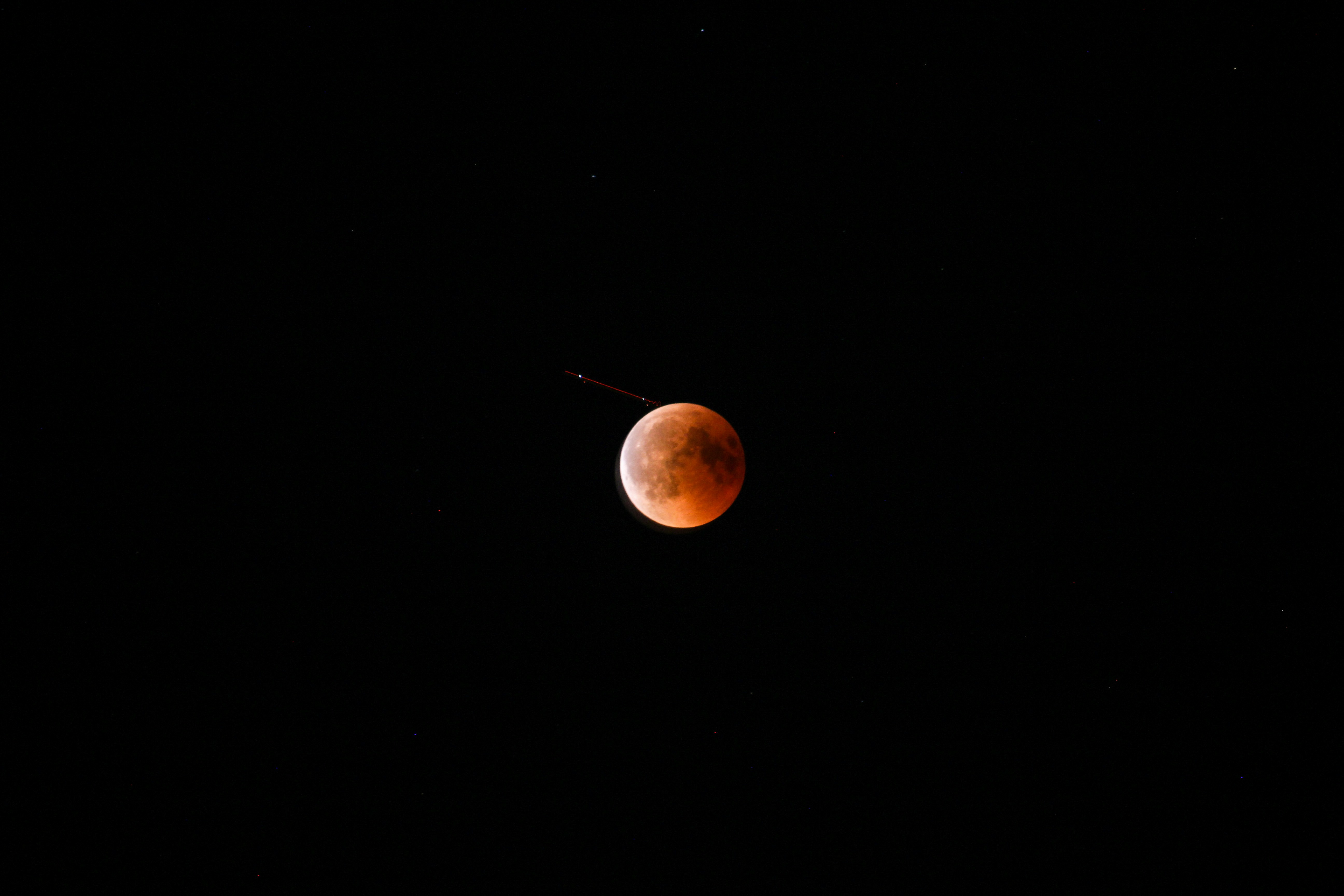 Blood moon glowing against a pitch-black sky during a lunar eclipse.