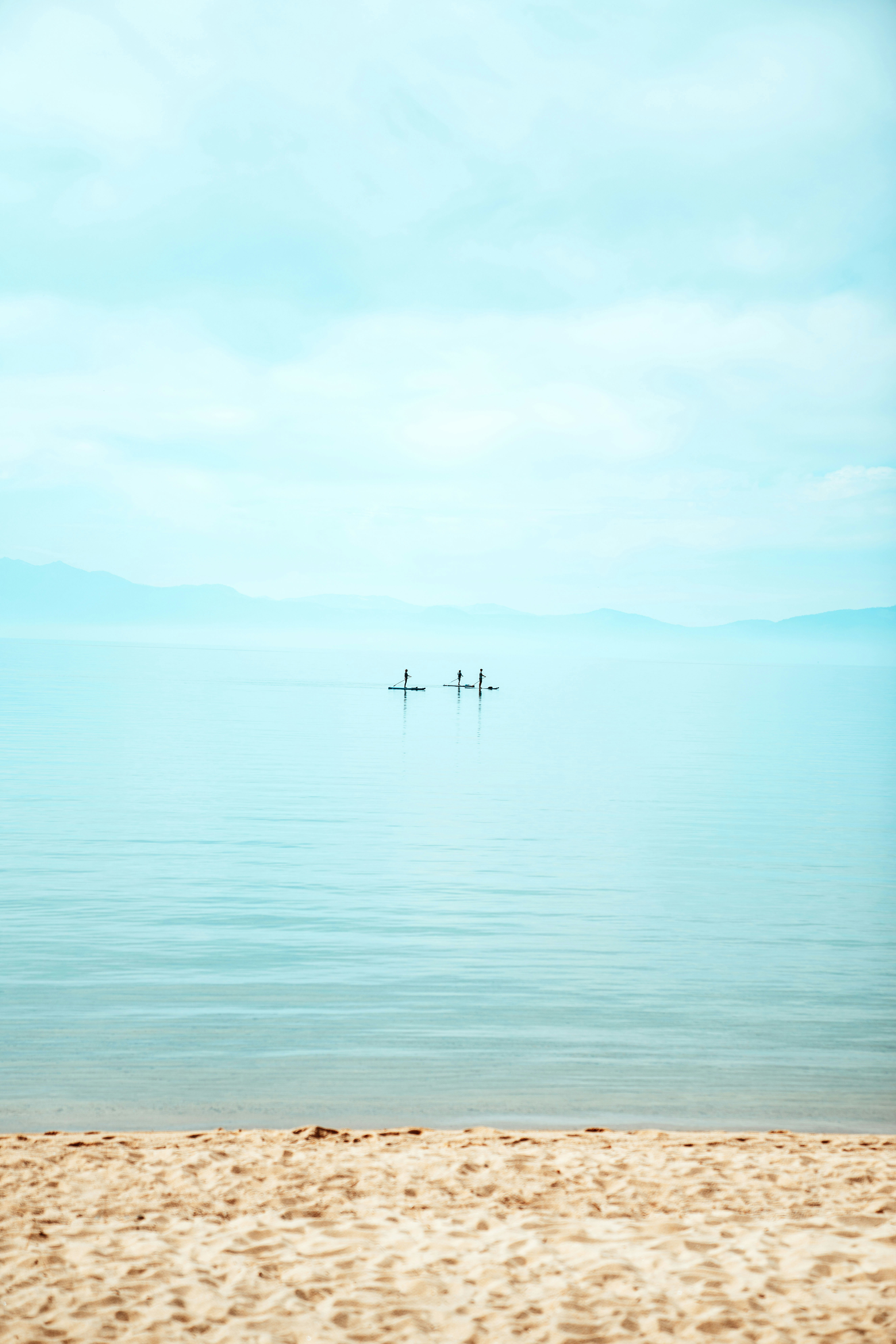 Edge of Dawn: Three Silhouettes on a Glassy Sea