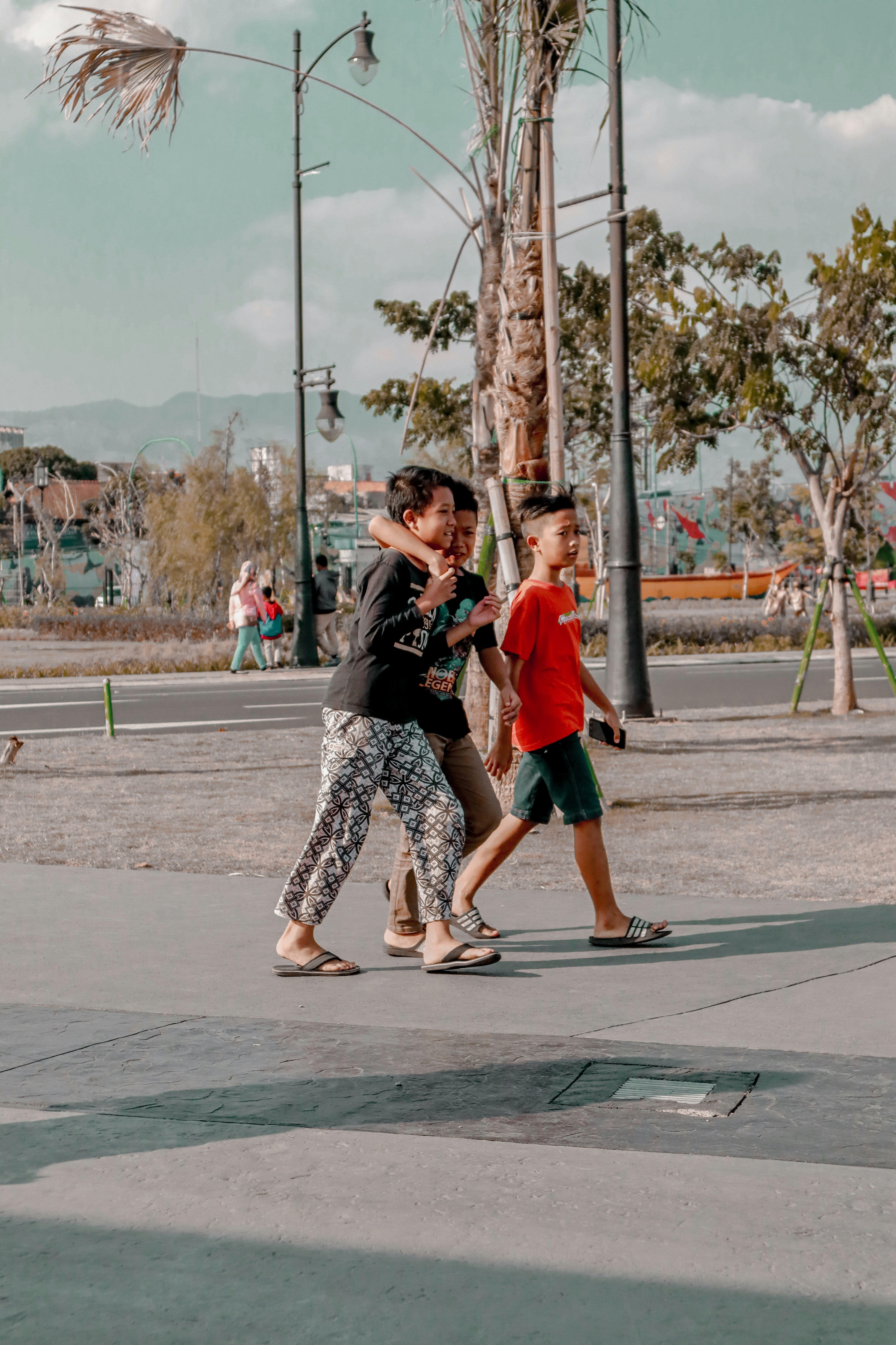 Three boy walking on road at daytime photo – Free Street photography ...