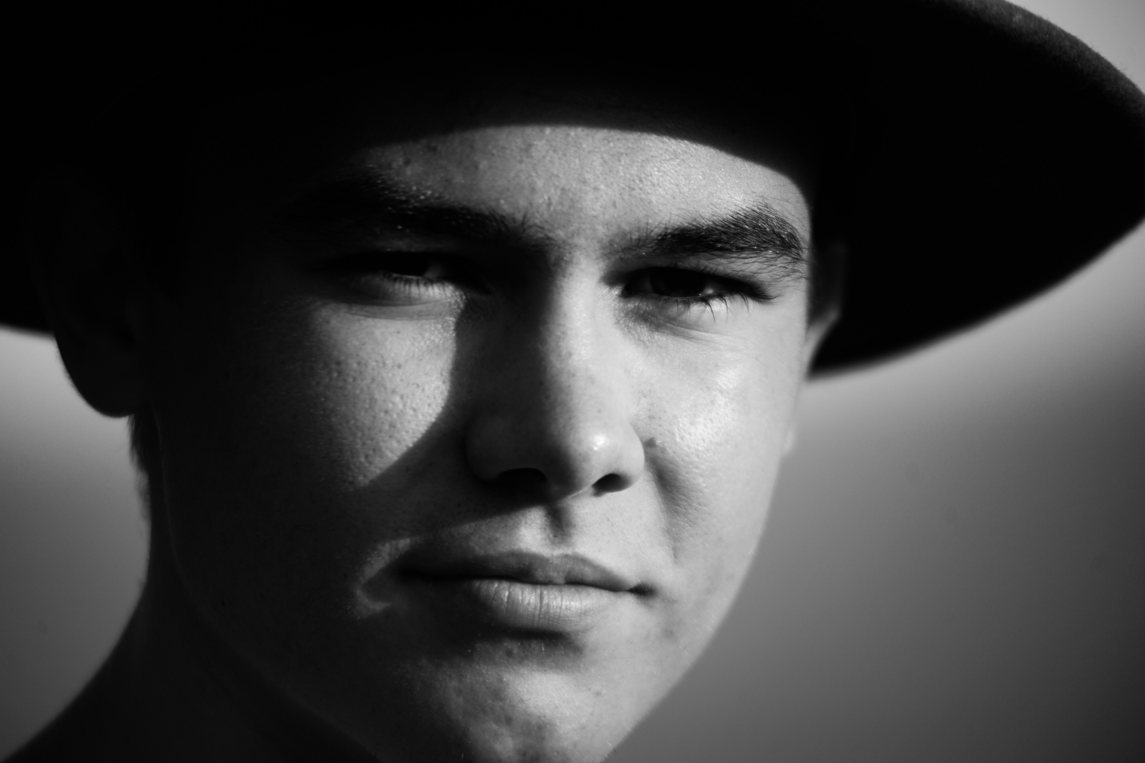 Gaze in Shadow: Mono Portrait Beneath a Wide Brim