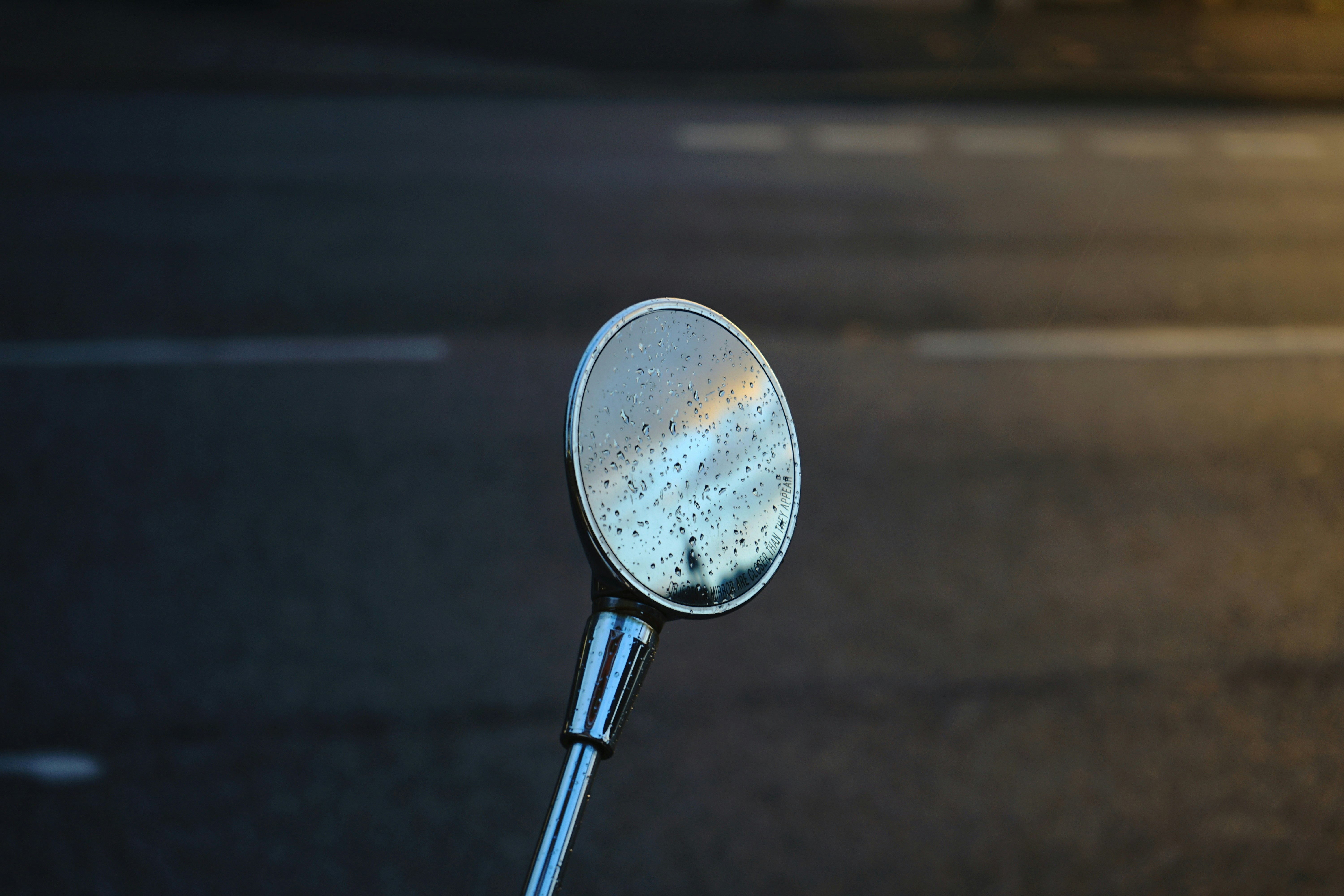 Rain-Streaked Mirror Under Streetlight on a Quiet Road