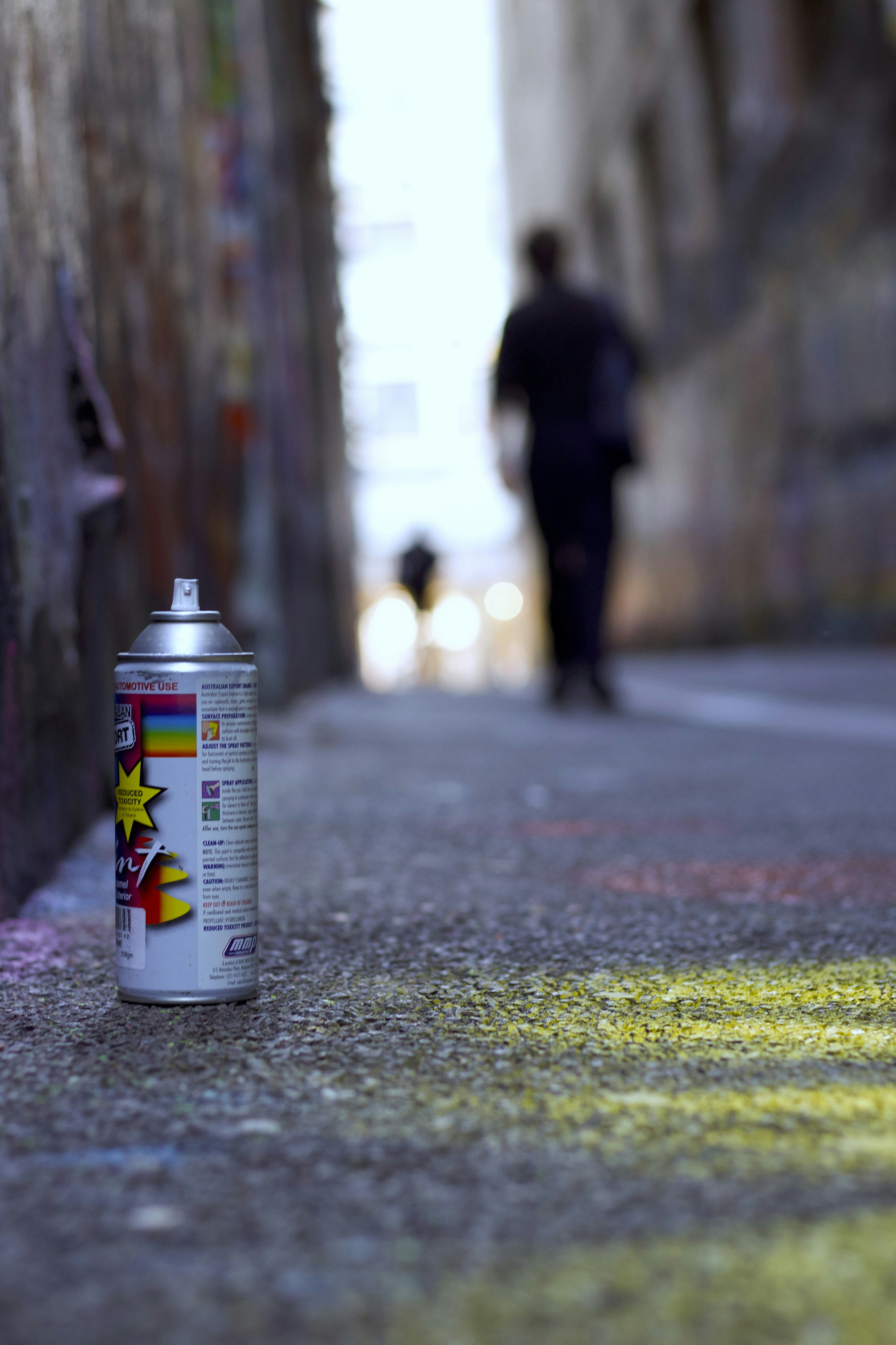 Spray Can at the Alley's Edge: Neon Graffiti and a Distant Figure