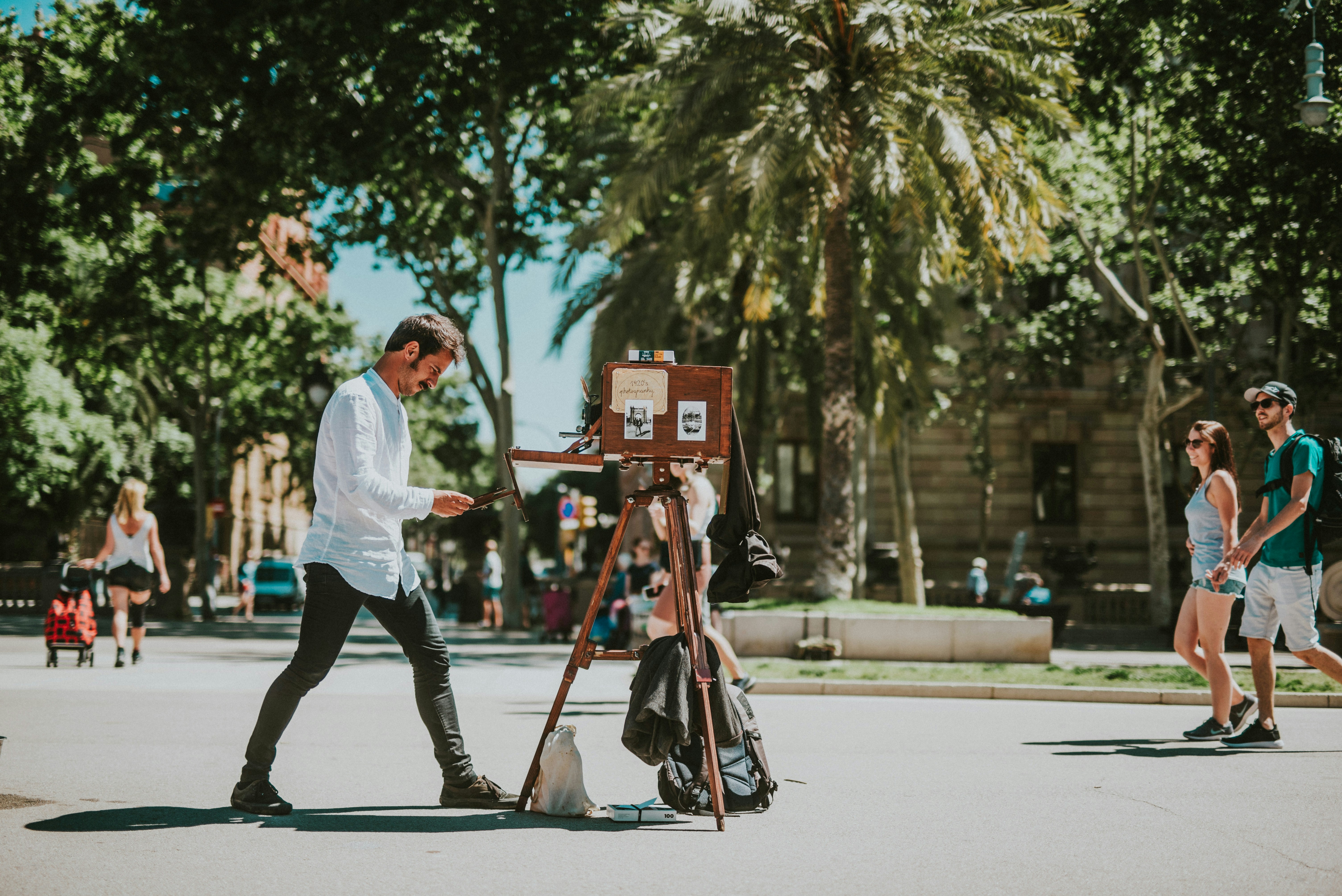 Sunlit Sidewalk Studio: A Portable Street Booth Anchors a Quiet Park Scene