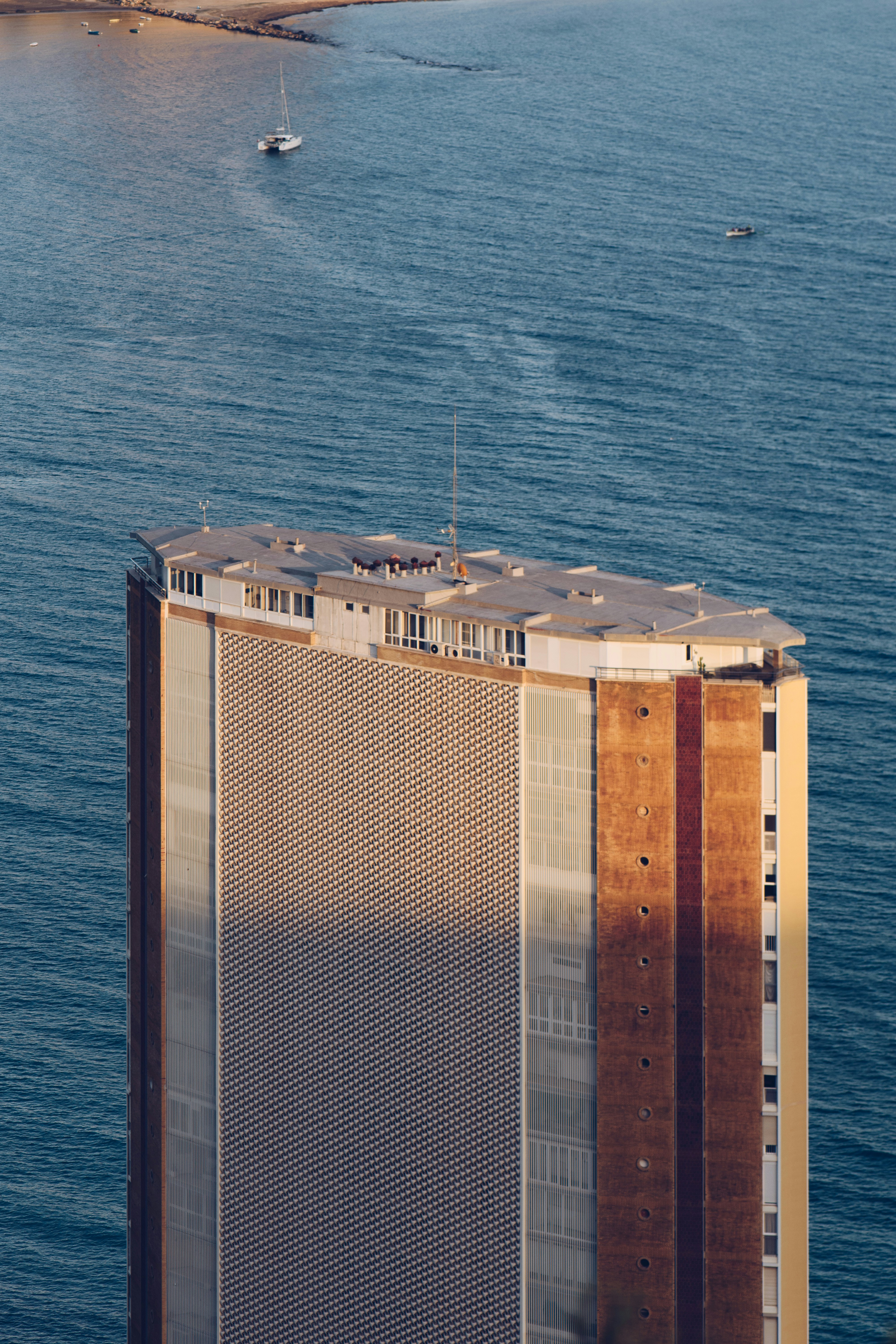 Harbor Monolith: A Seaside High-Rise Standing Against the Blue