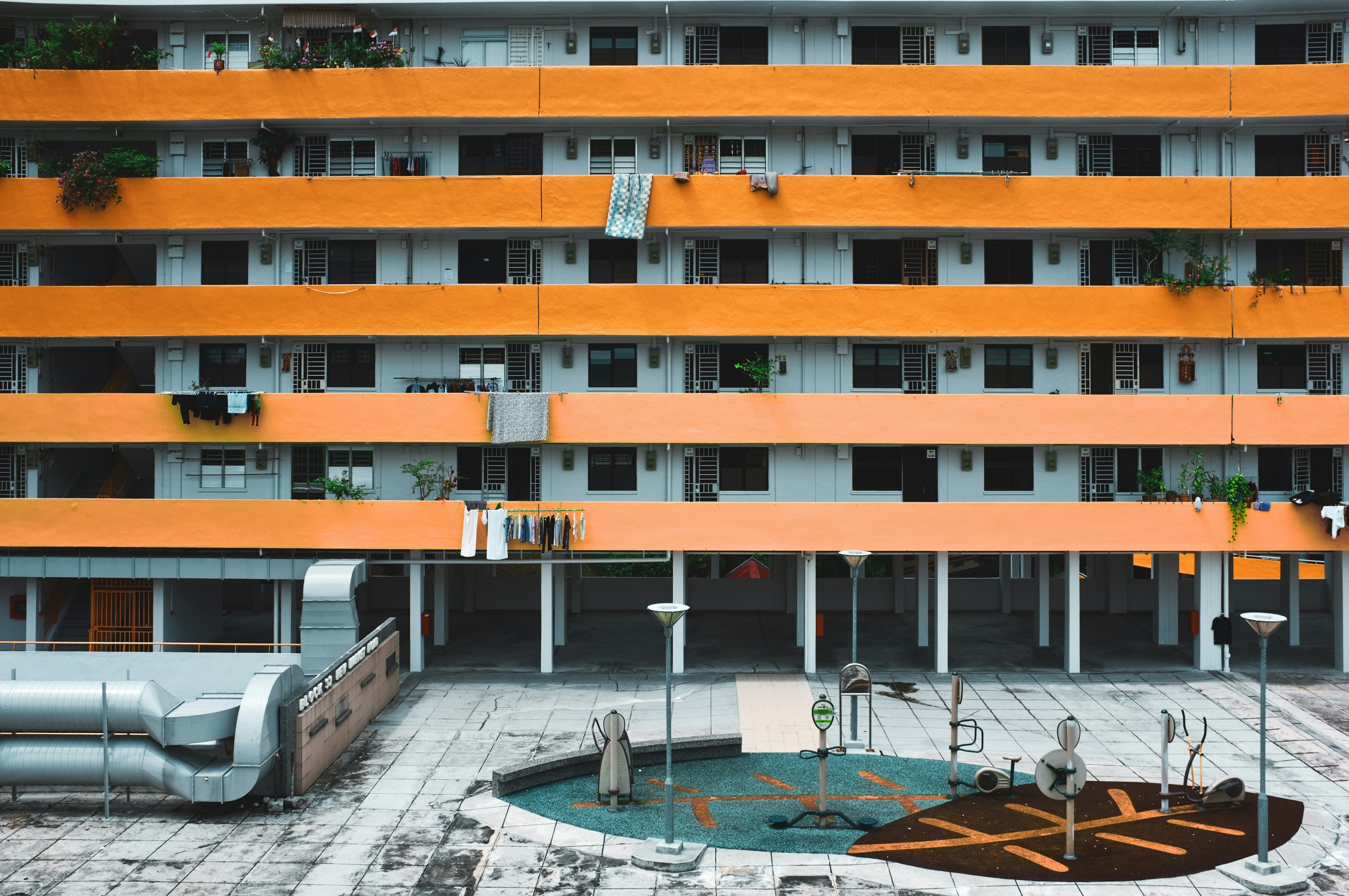Horizontal Tides: The Orange Facade Framing a Quiet Courtyard