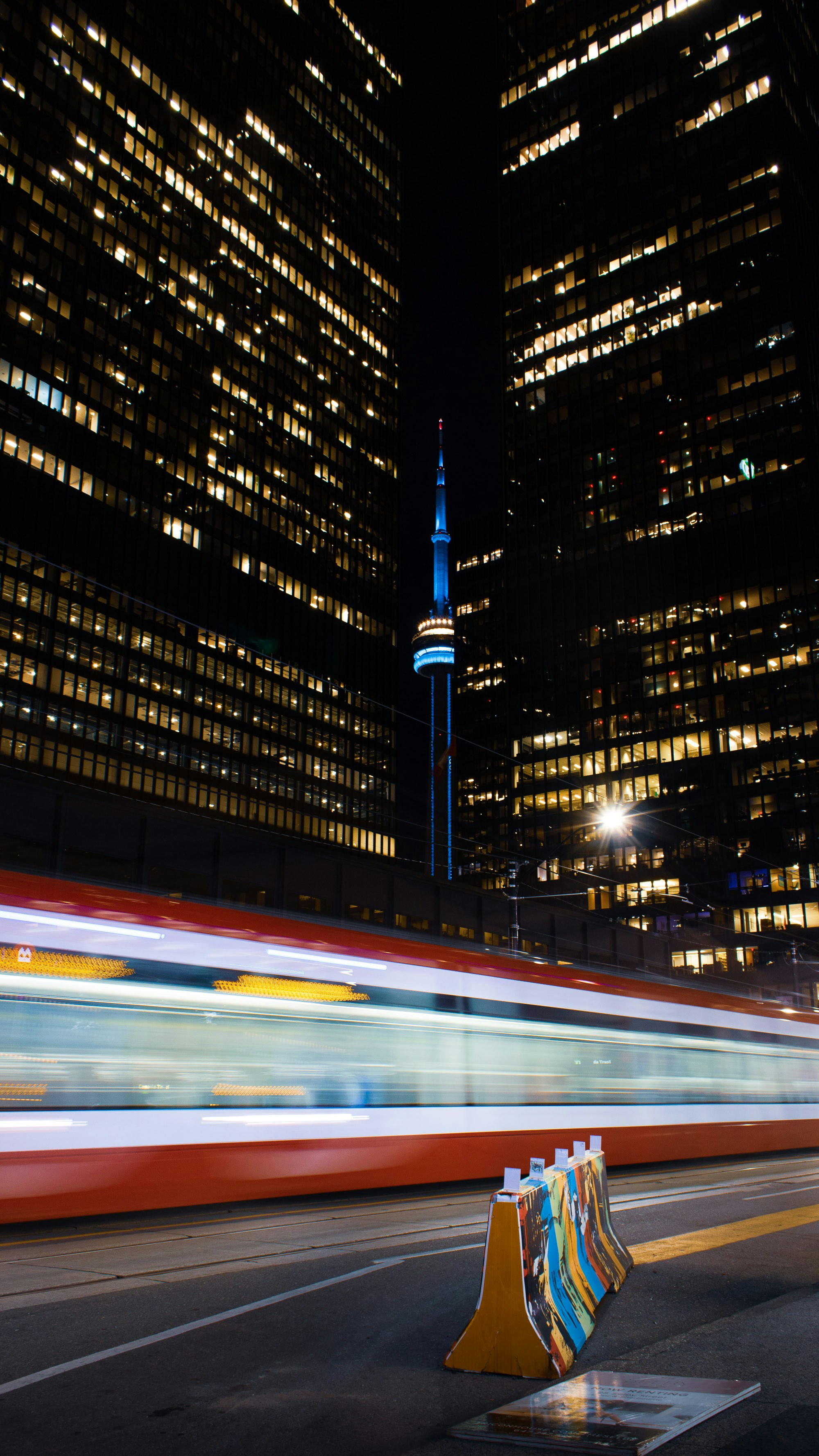 Blue Spire Over Toronto: Night Transit Through Glass Canopies