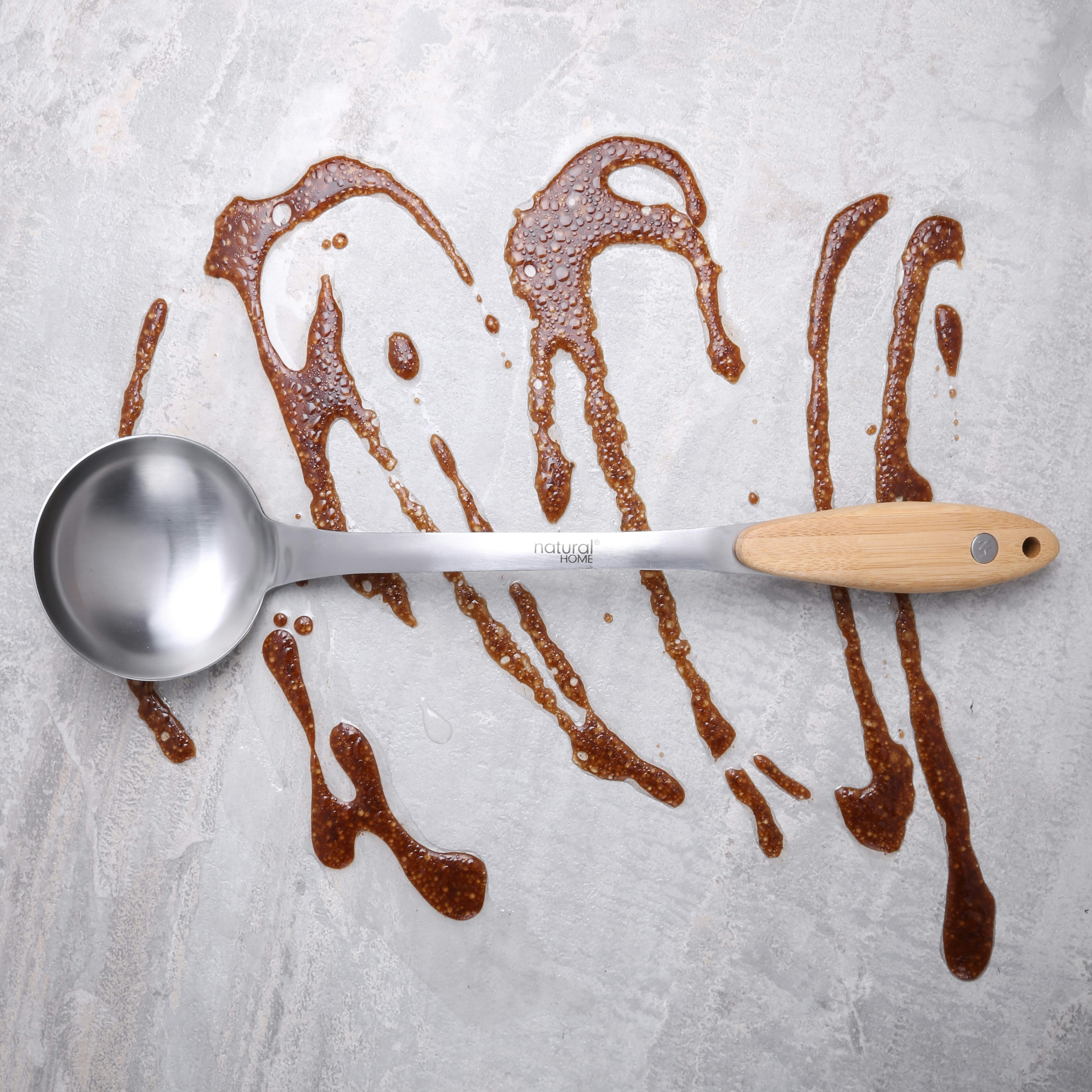 Metallic Ladle, Wooden Handle, and Cocoa Brown Streaks on Light Marble